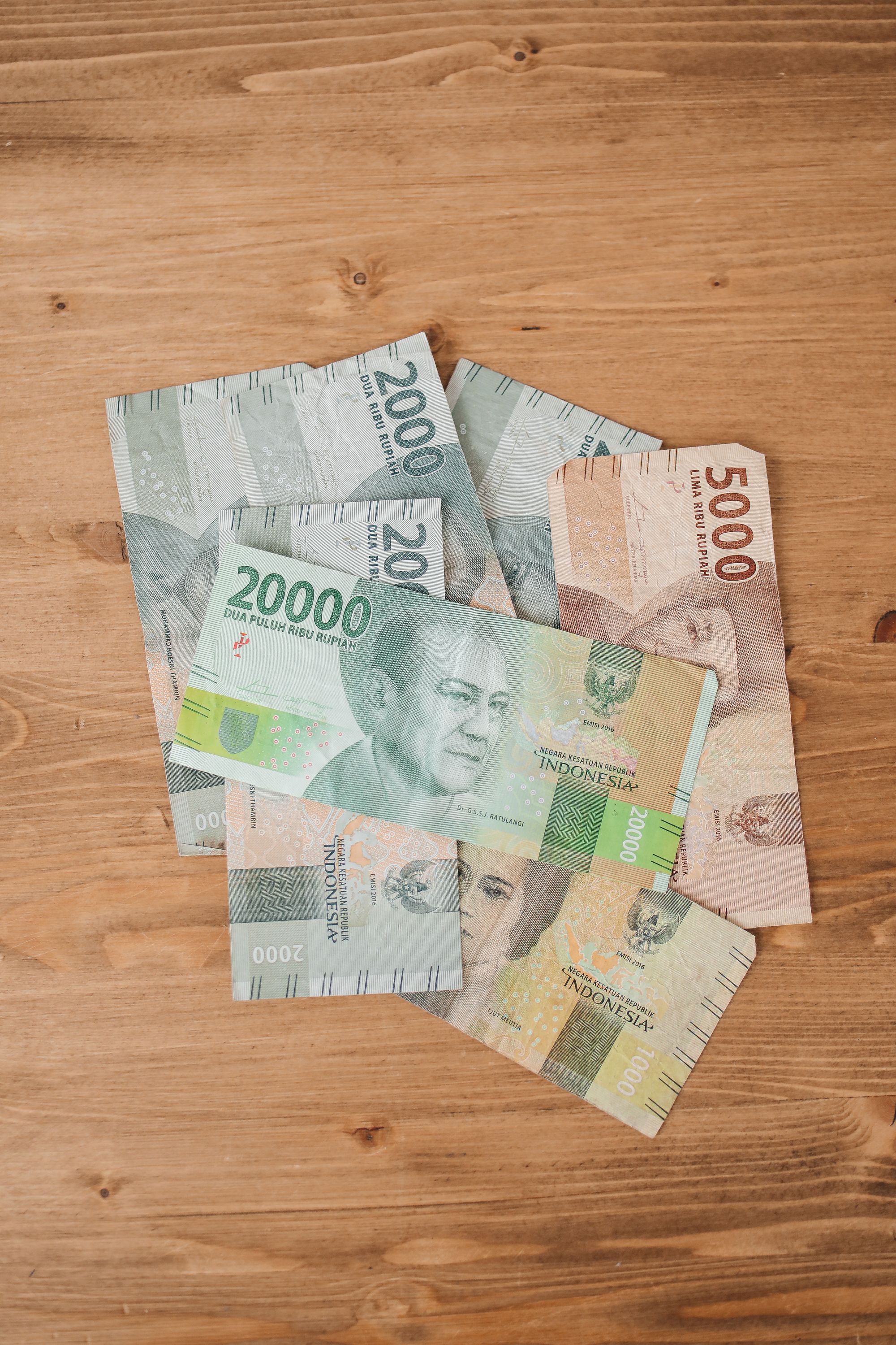 A Paper Money on a Wooden Table · Free Stock Photo