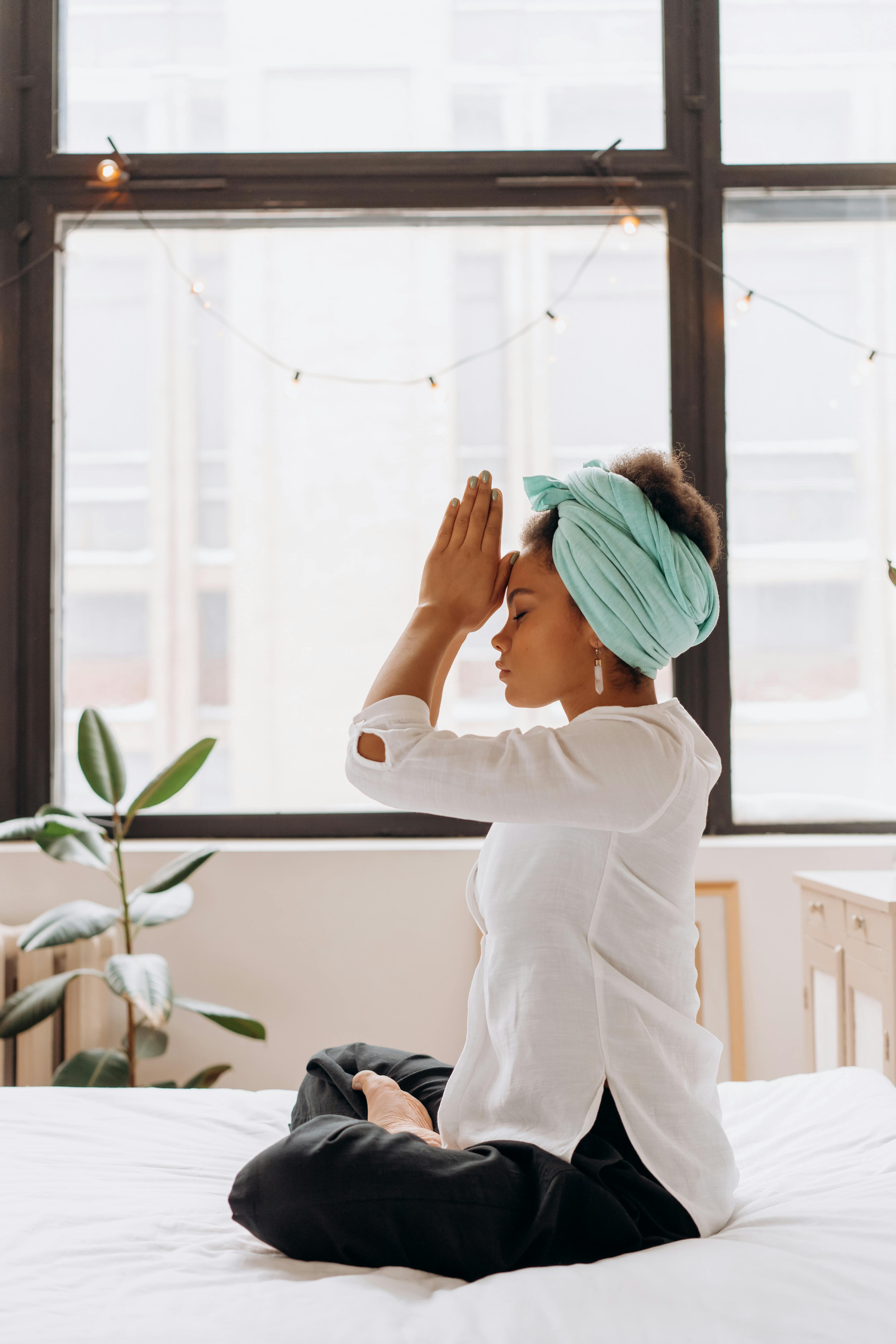 A Woman Meditating in Bed · Free Stock Photo