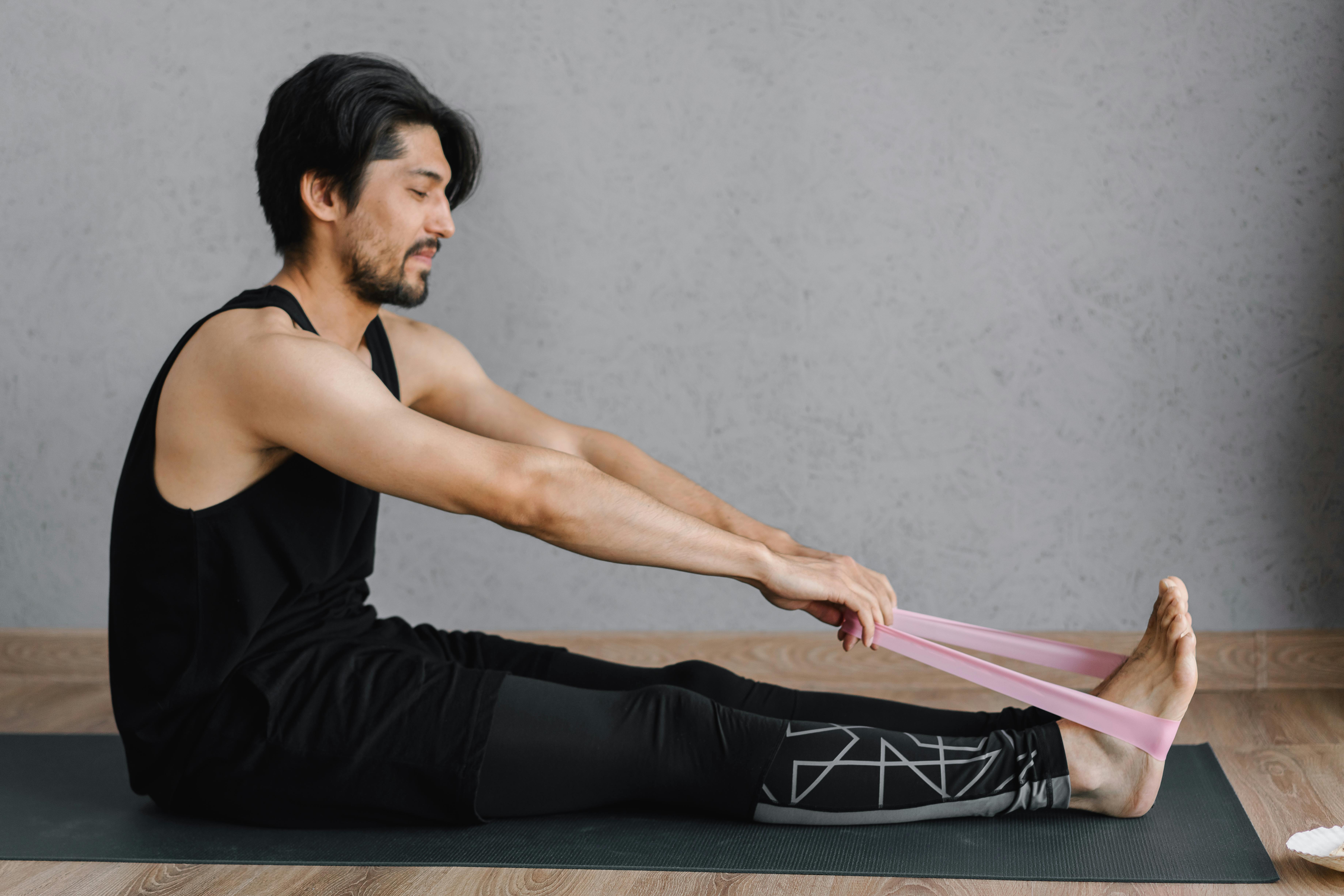 A Man Stretching on a Yoga Mat · Free Stock Photo