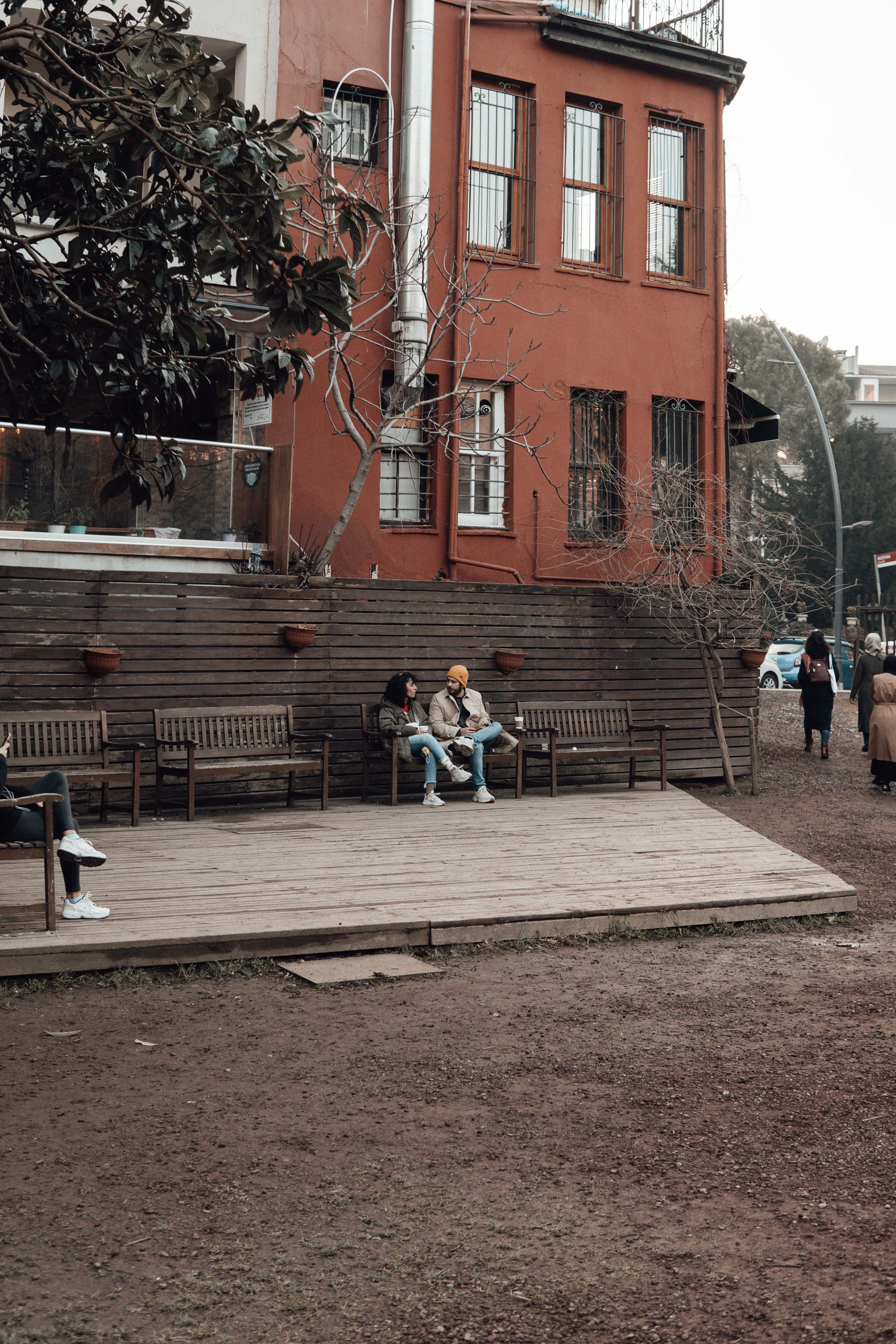 People sitting on bench near building · Free Stock Photo