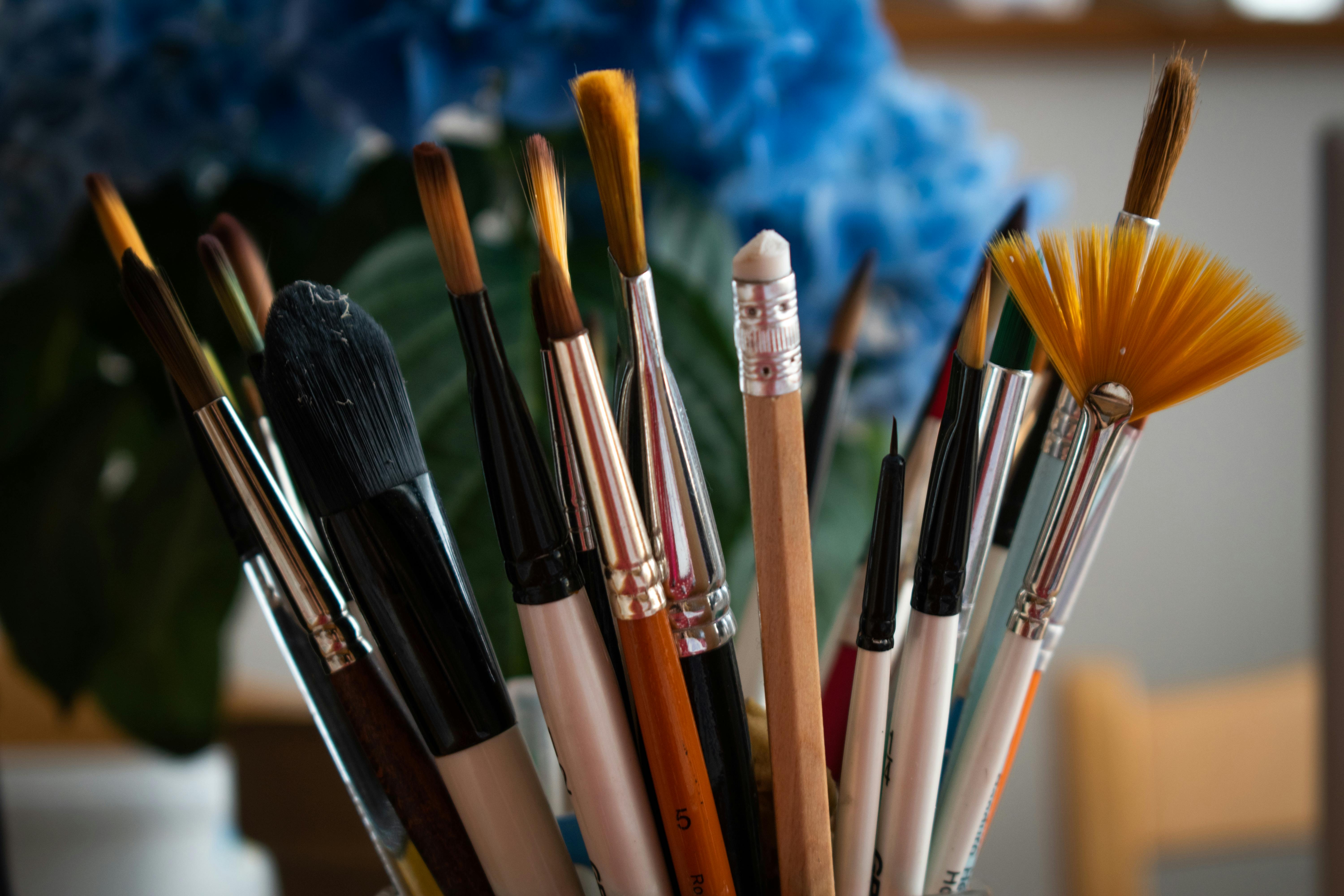 Close-Up Photograph of a Pencil Near Paintbrushes · Free Stock Photo