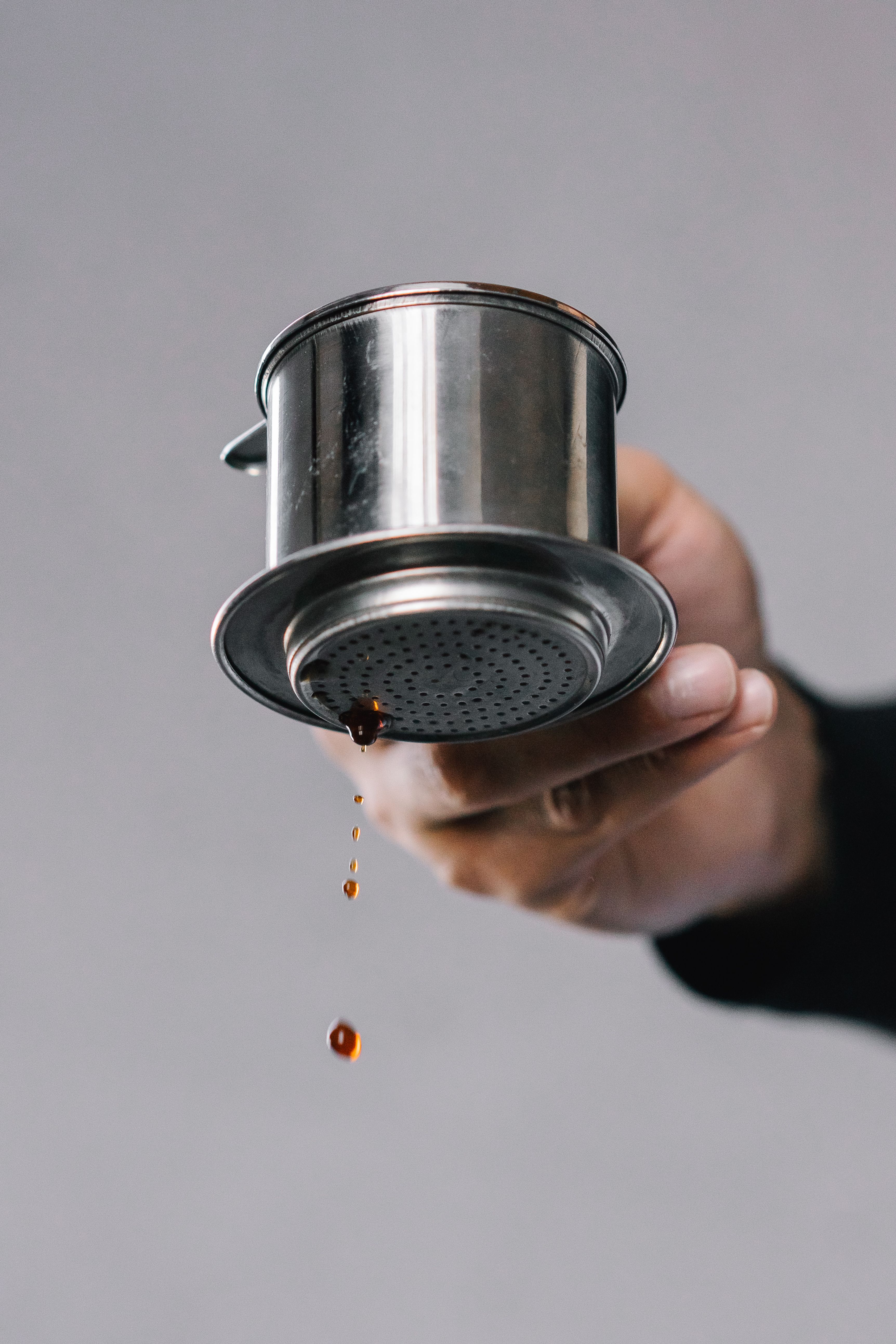 Person Holding A Dripping Stainless Steel Cup With Strainer · Free ...