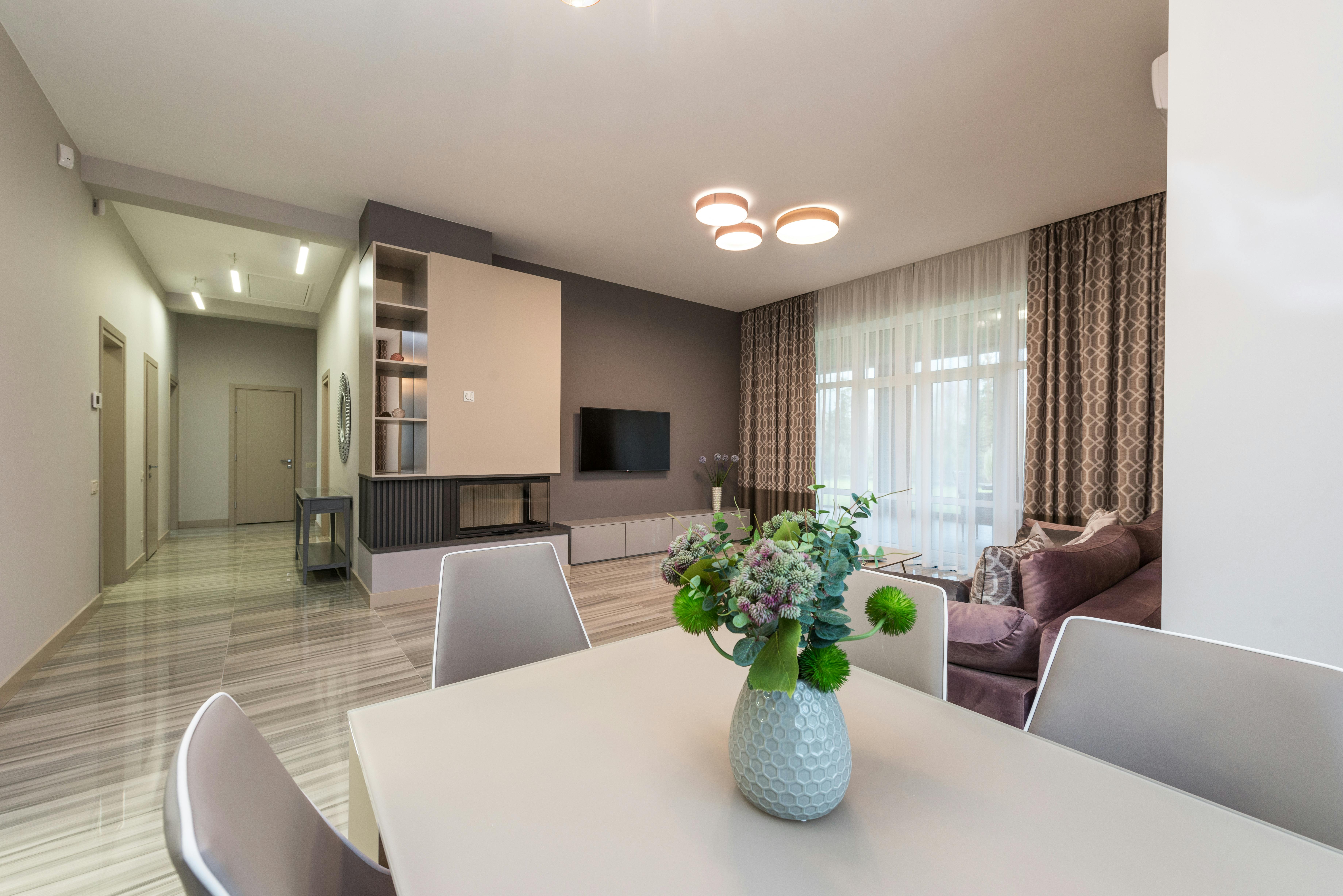 Modern simple frame hanging on wall between windows · Free Stock Photo