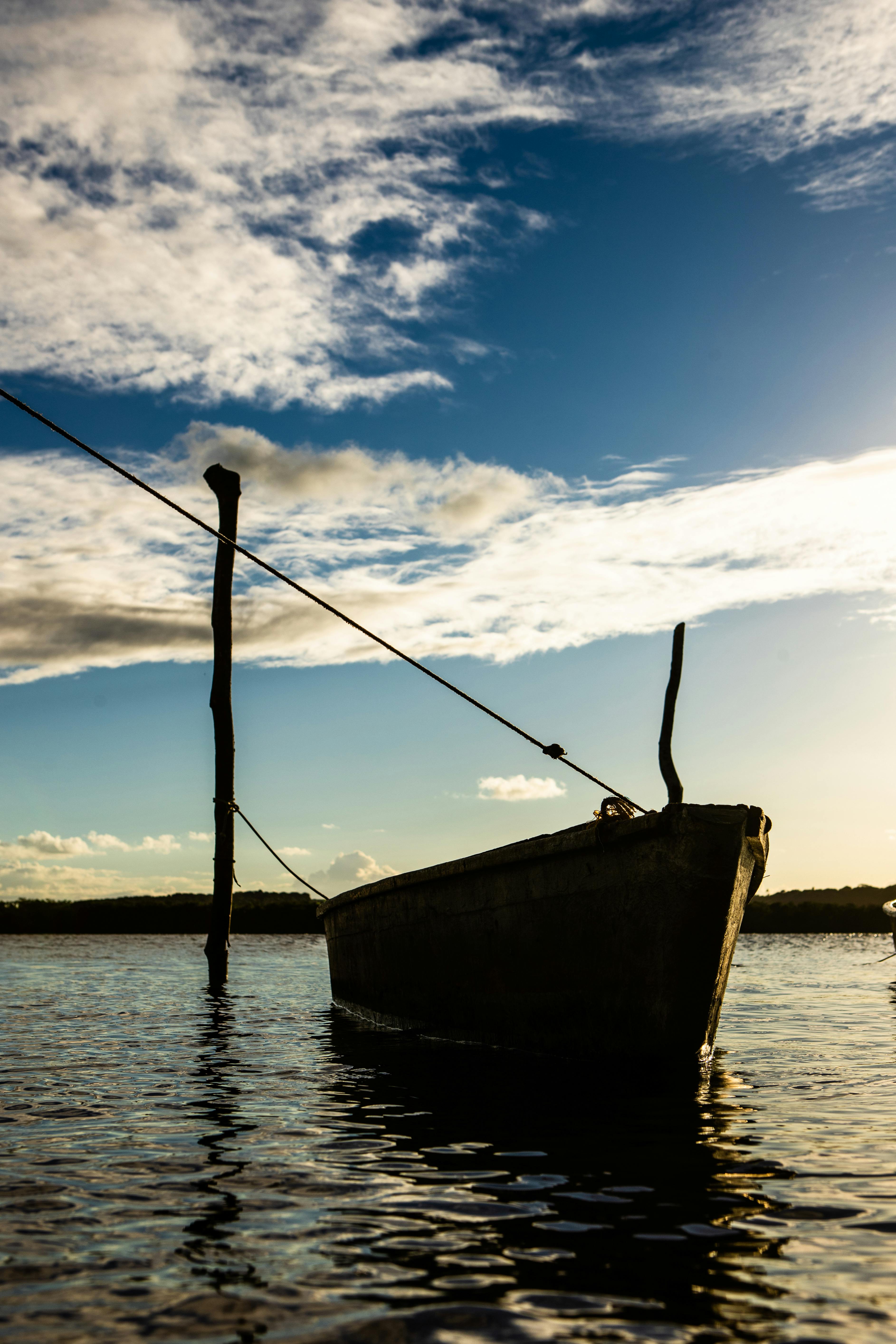 Silhouette of a Rowboat on the Sea during Sunrise · Free Stock Photo