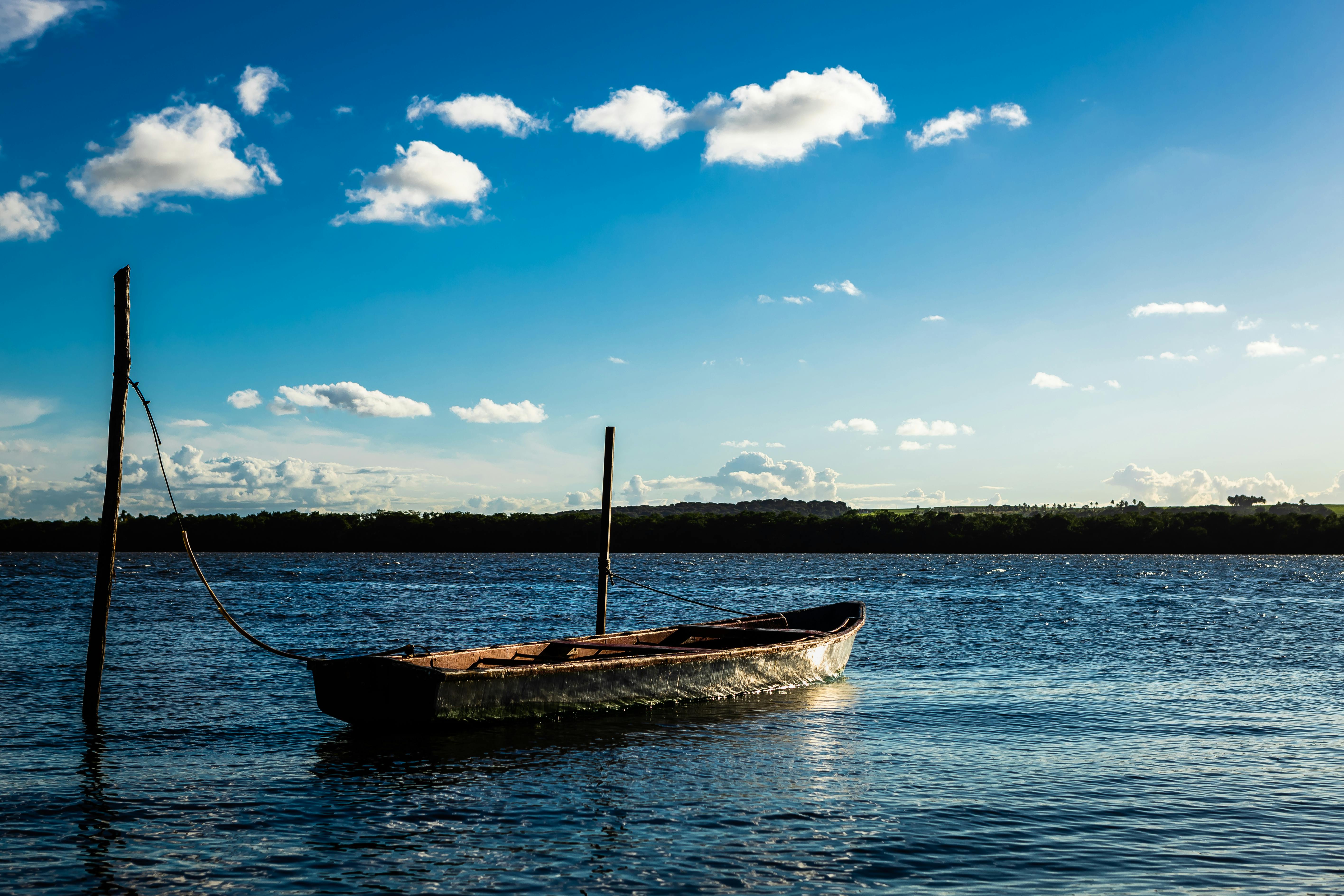 Wooden Small Boat Floating on a Calm Water · Free Stock Photo
