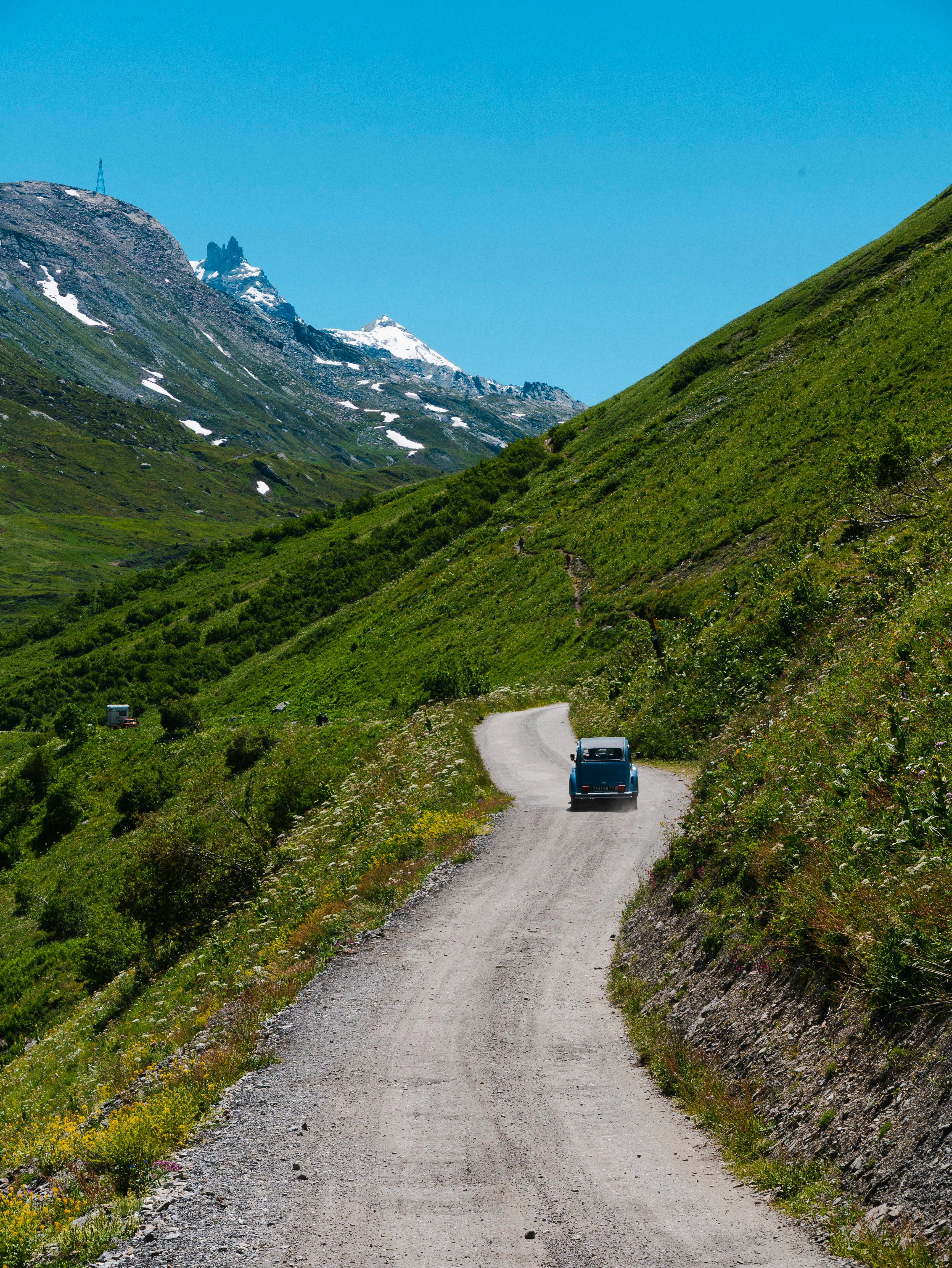 A Blue Car Traversing an Countryside Road · Free Stock Photo