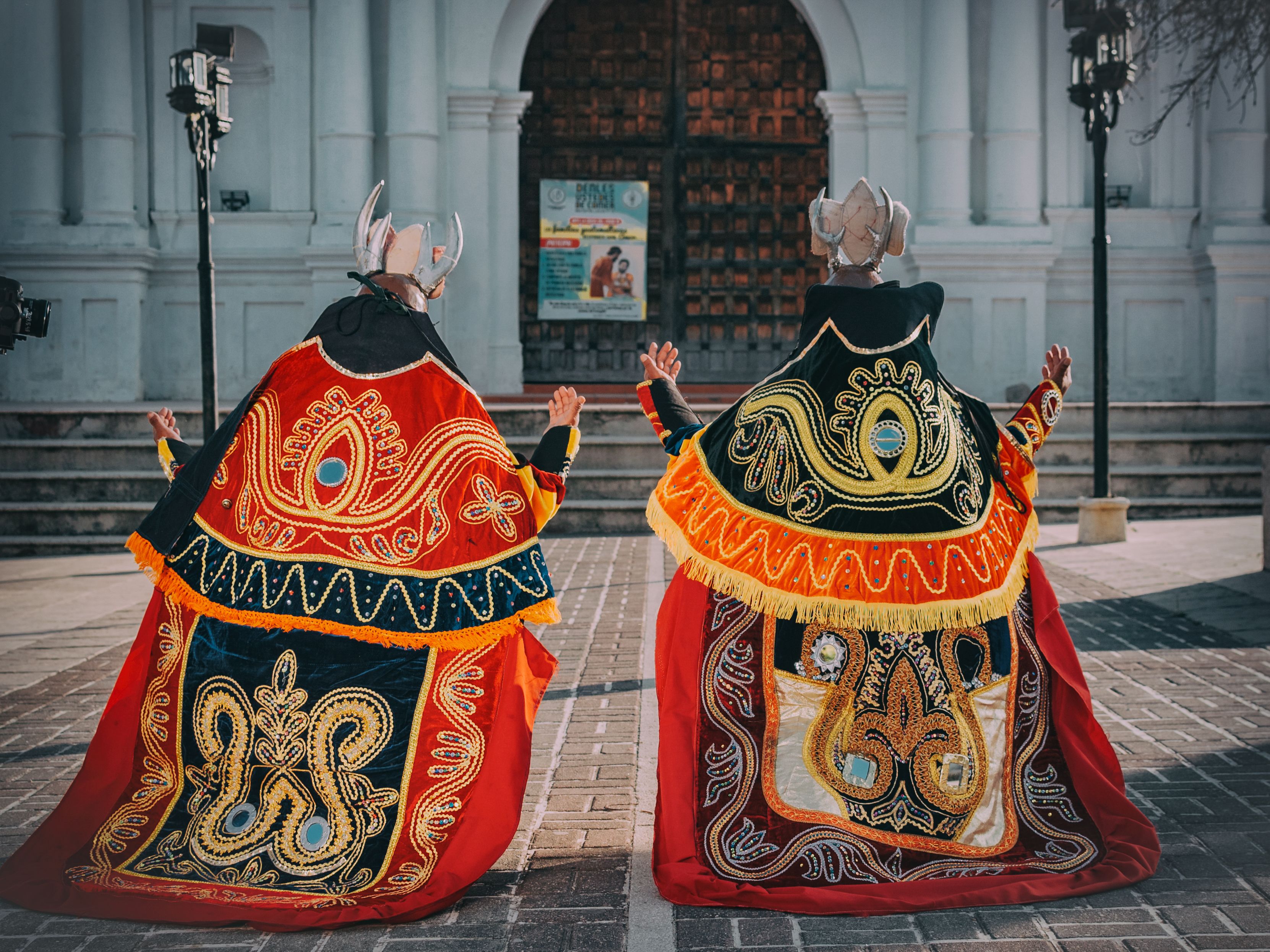 Priests in Colorful Capes Kneeling in Front of a Church · Free Stock Photo