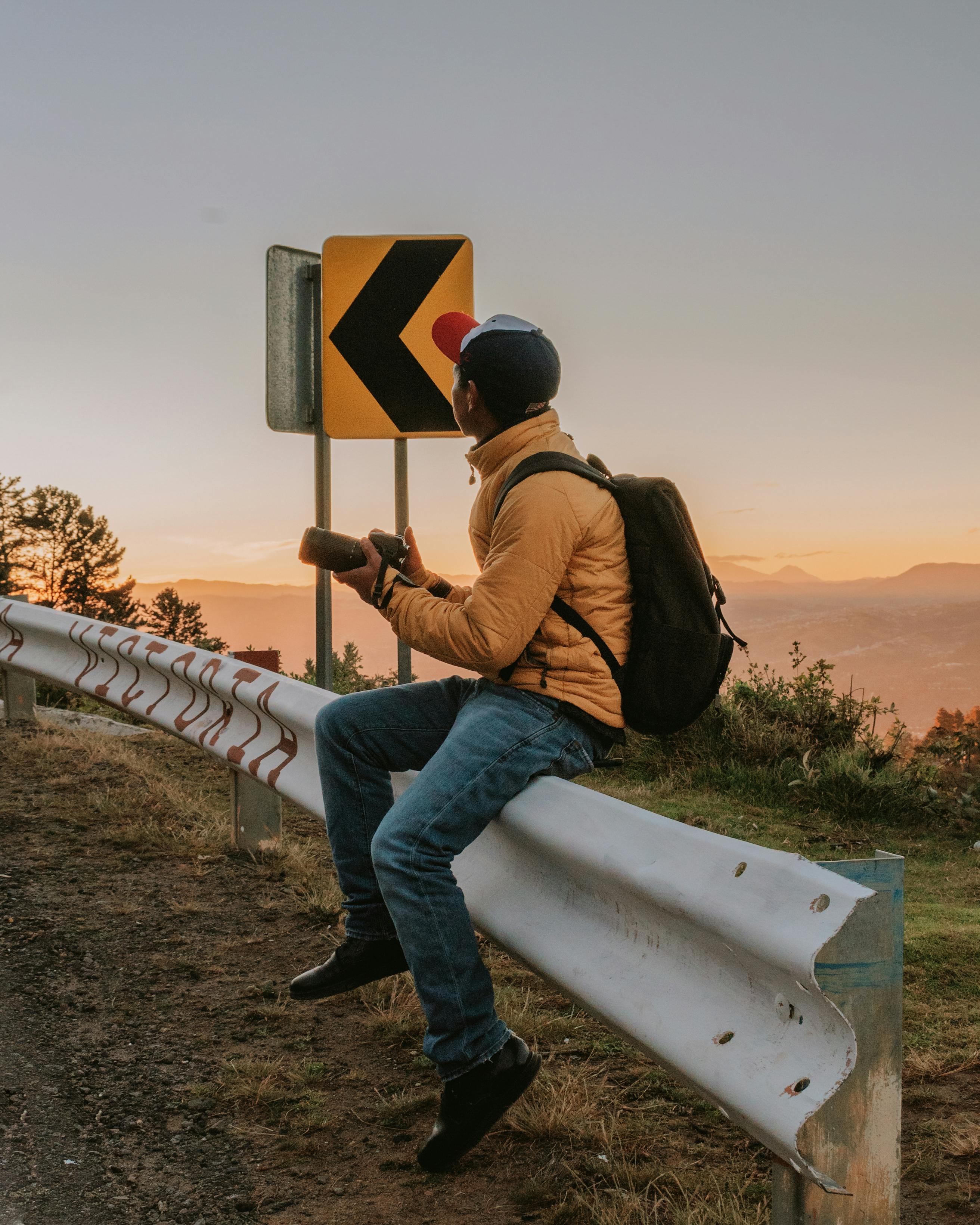 Man Sitting on Guard Rail · Free Stock Photo