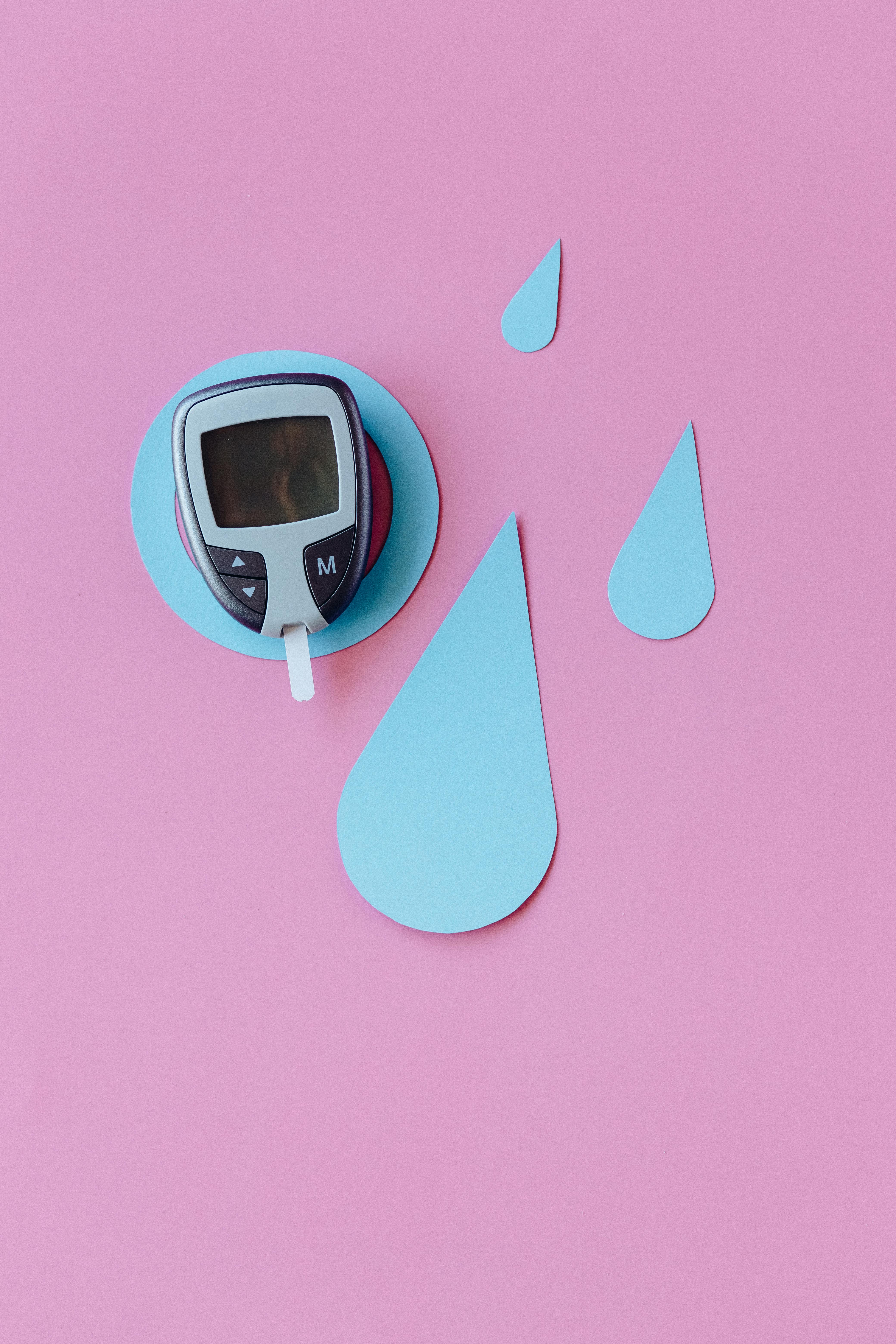 Blue Paper Cut Outs and Glucometer on Pink Surface · Free Stock Photo