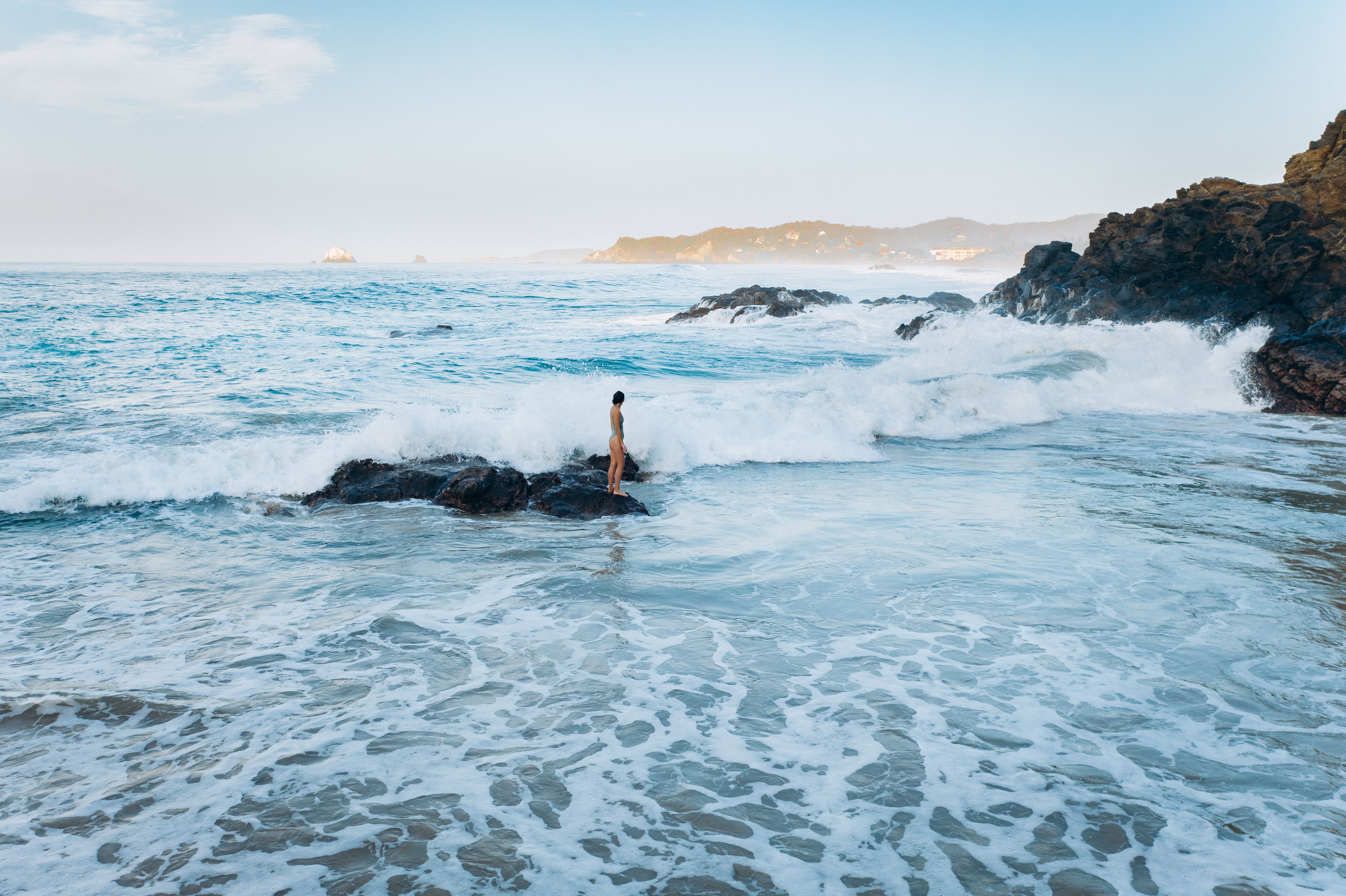 Person Standing on a Rock on the Beach · Free Stock Photo