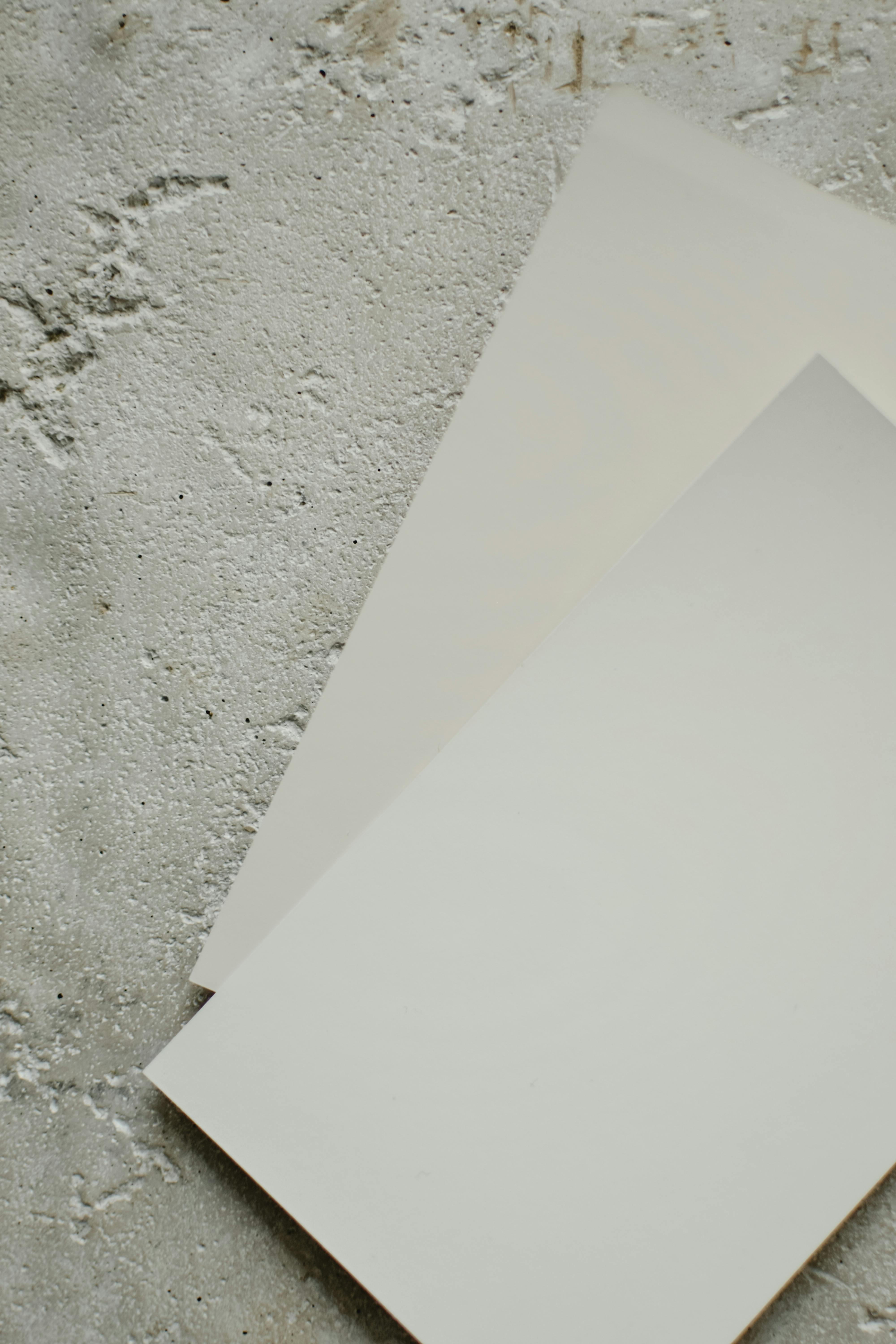 A White Papers on a Concrete Surface · Free Stock Photo