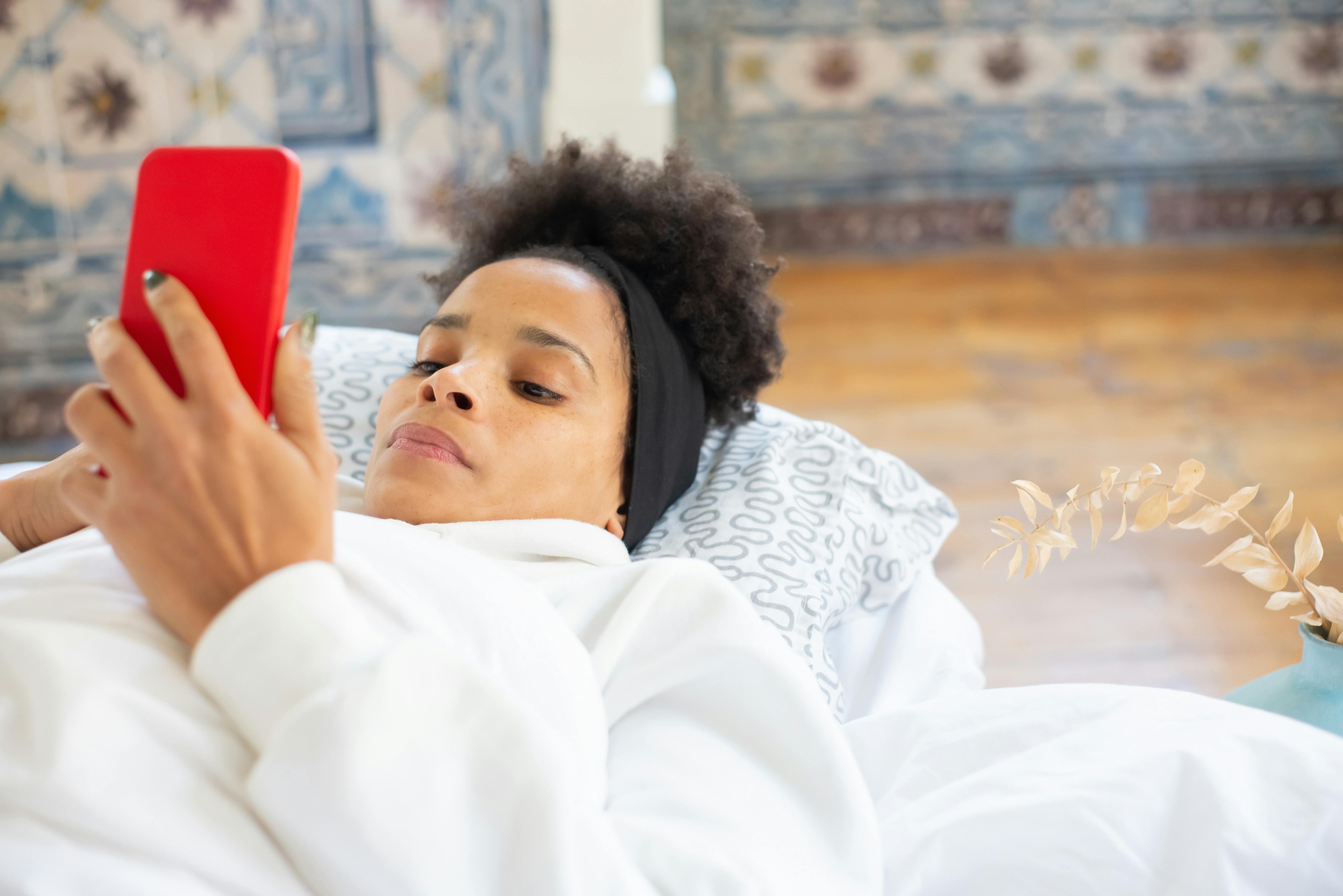 Woman Laying on Bed Using a Smart Phone · Free Stock Photo