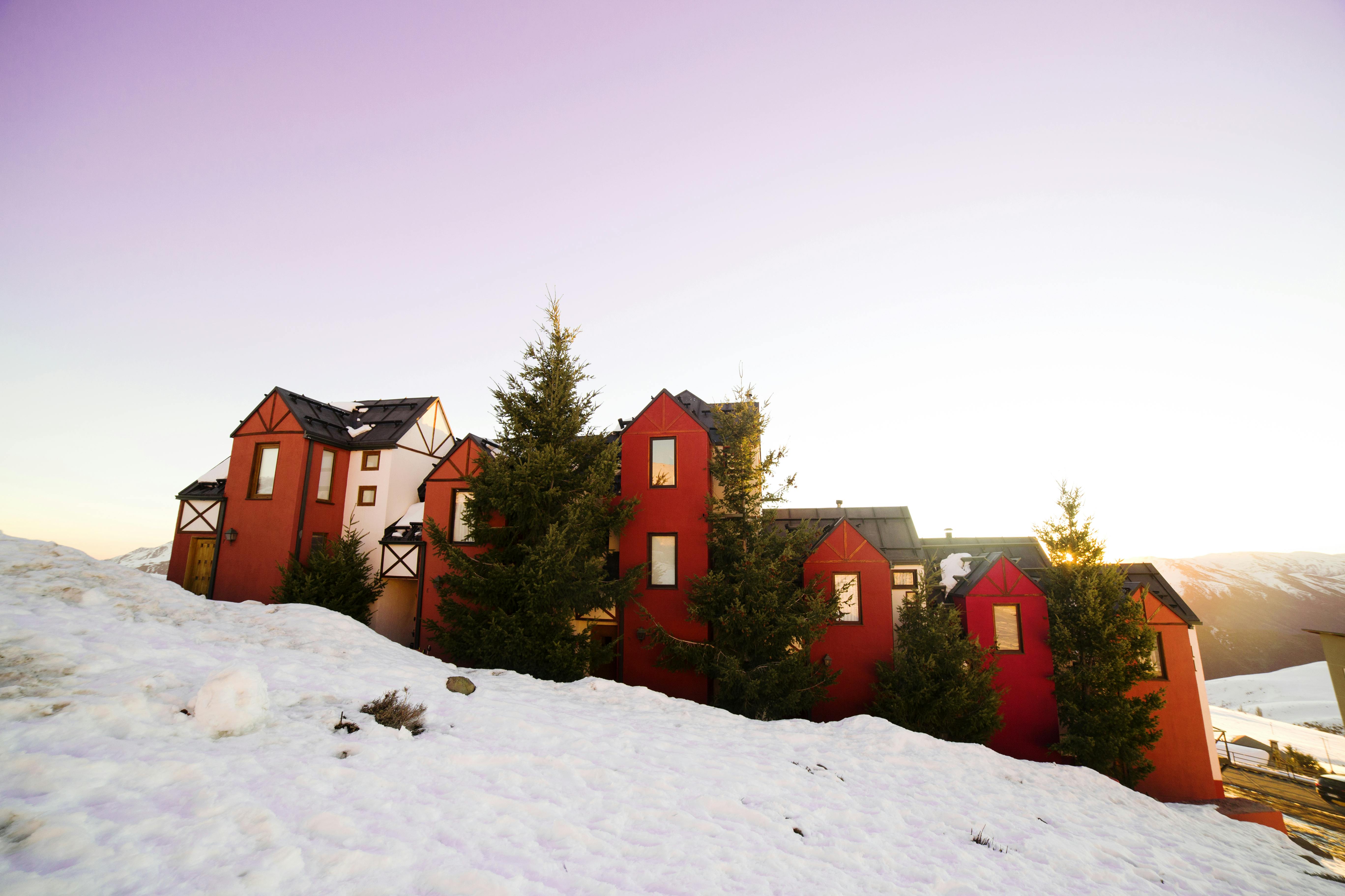 Cozy red house in snowy countryside on sunny day · Free Stock Photo