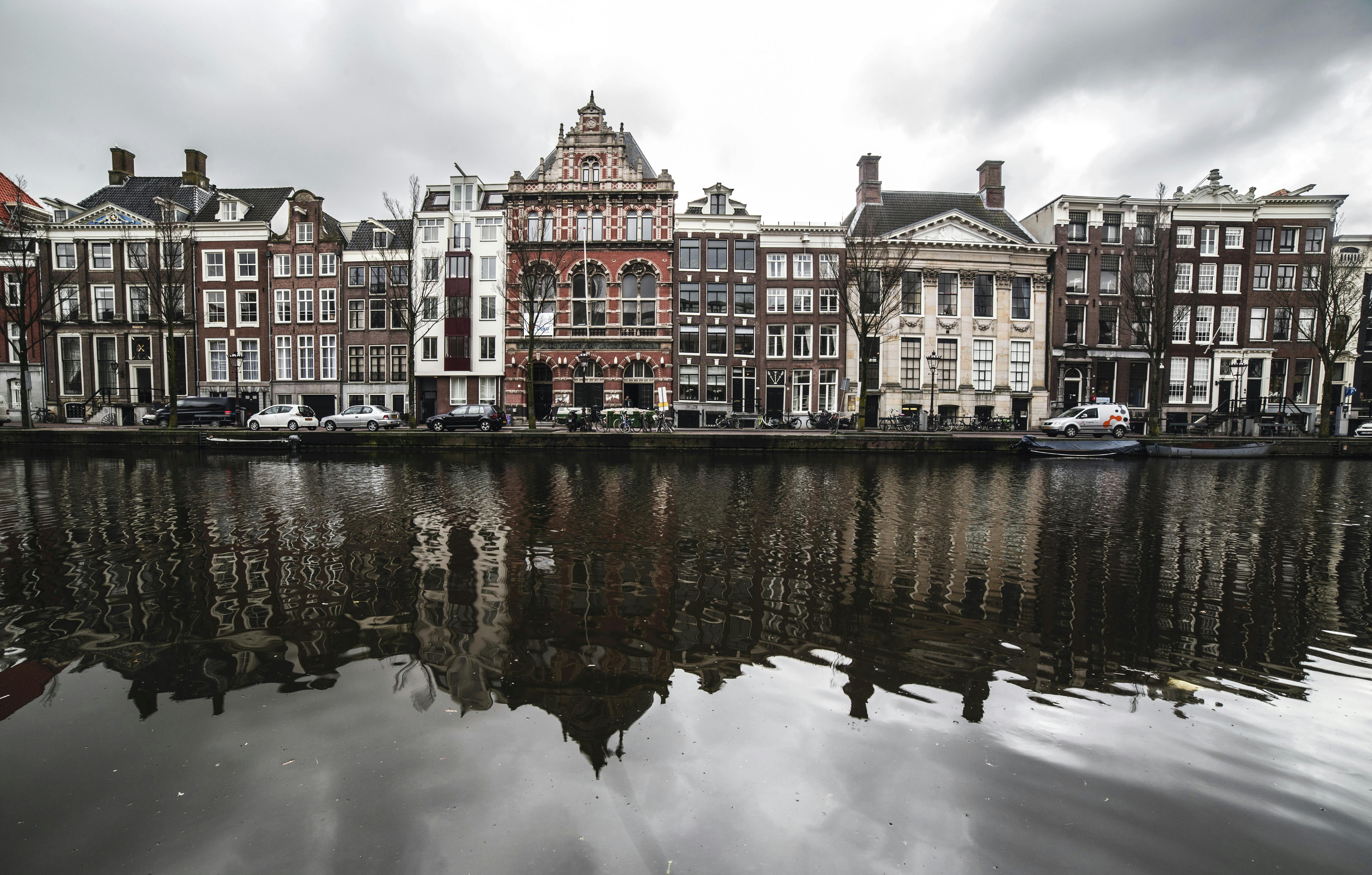 Row of typical historical buildings reflecting on river · Free Stock Photo