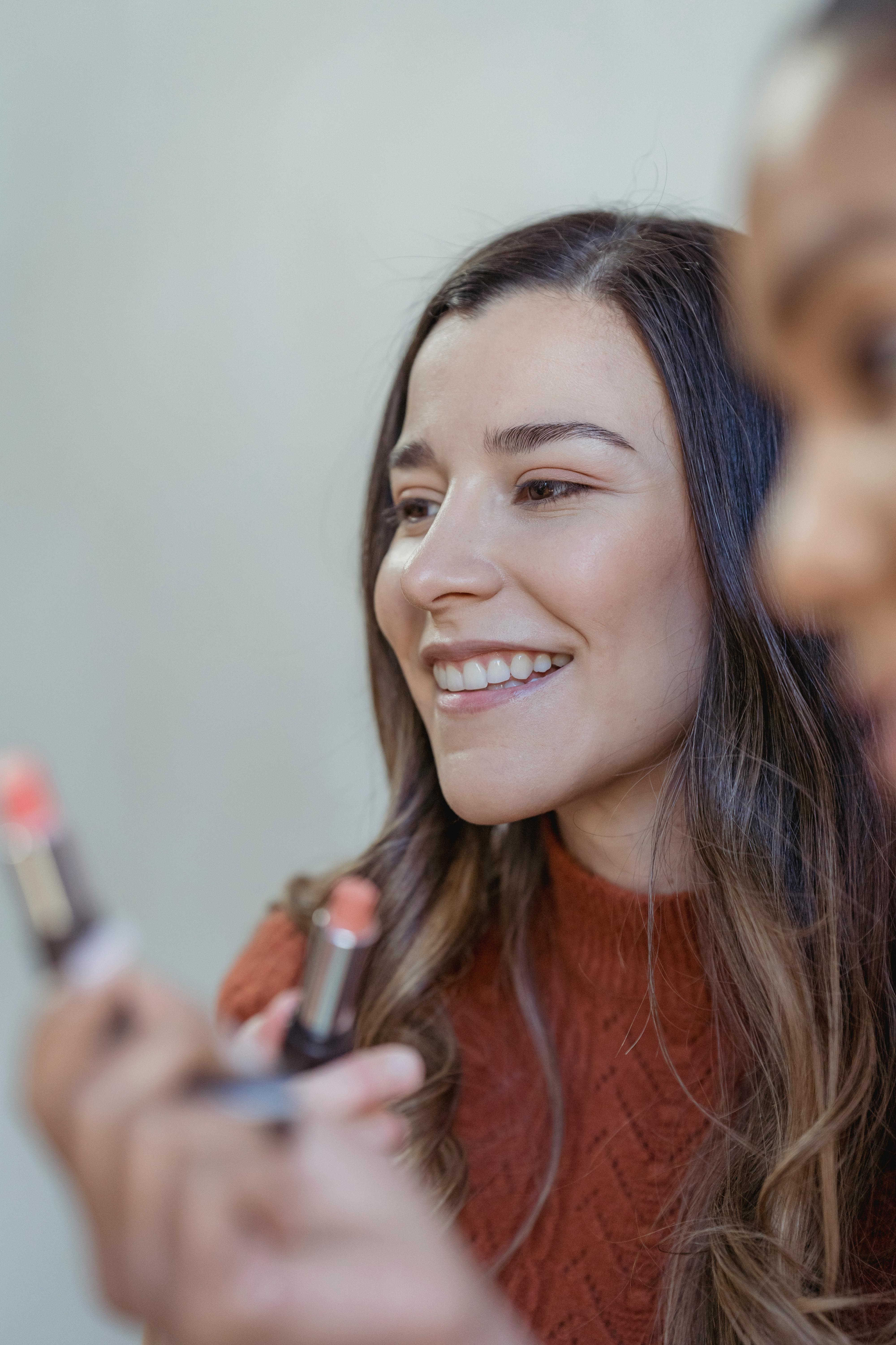 Positive diverse friends applying lipstick · Free Stock Photo