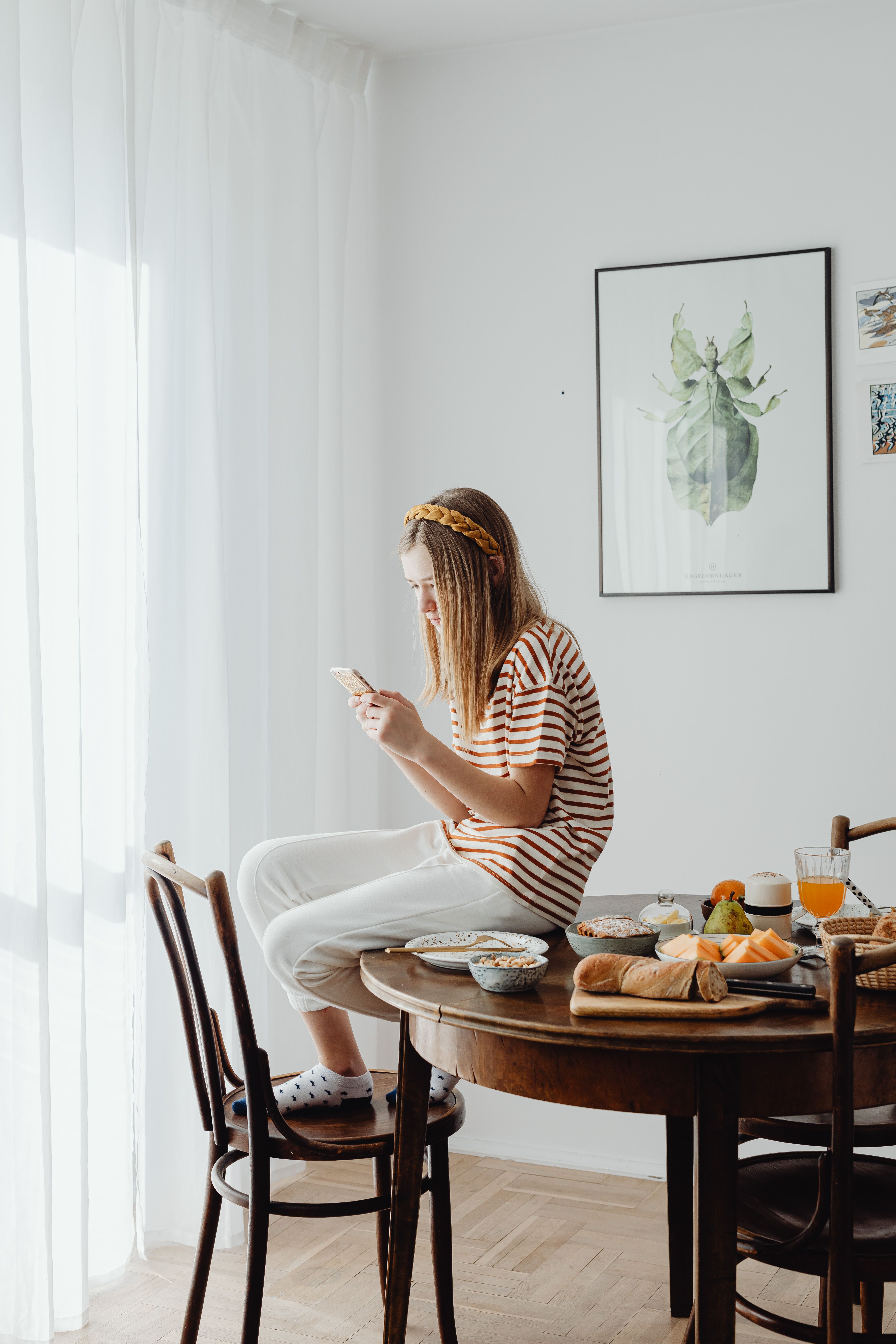 A Woman Sitting on a Dining Table · Free Stock Photo