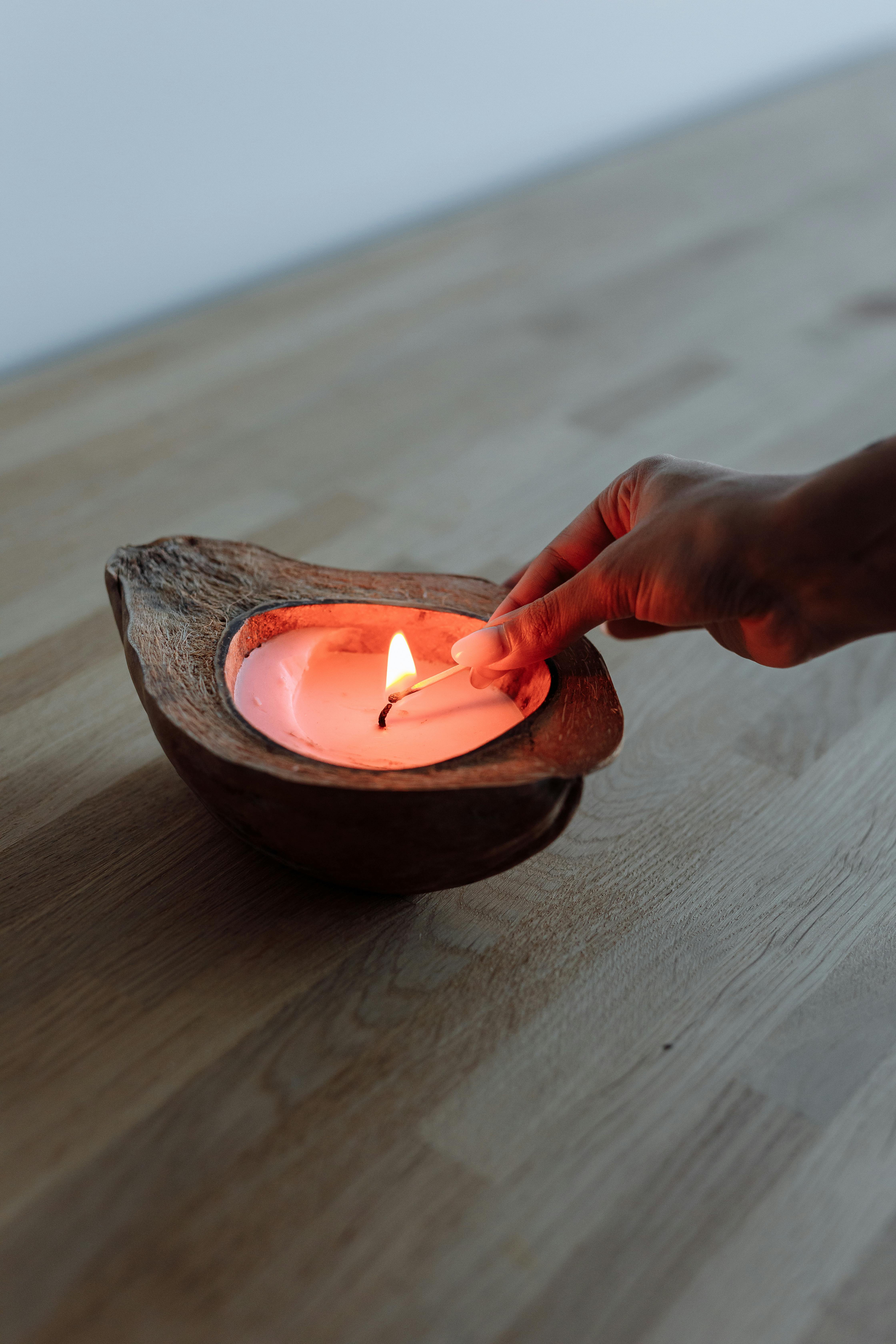 Close-Up Photo of a Person's Hand Lighting a Candle · Free Stock Photo