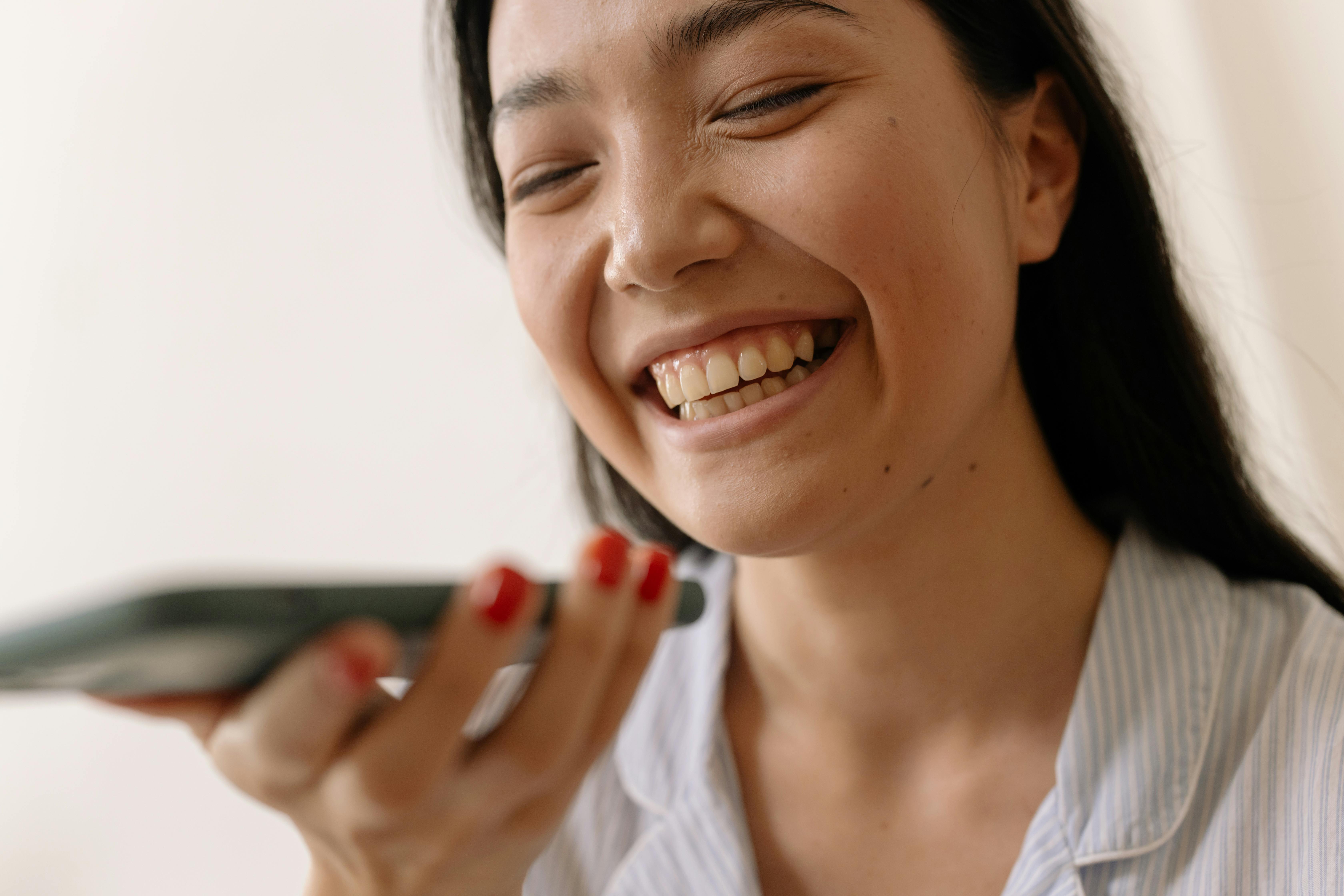 Young Woman lying on Bedside holding a Telephone · Free Stock Photo