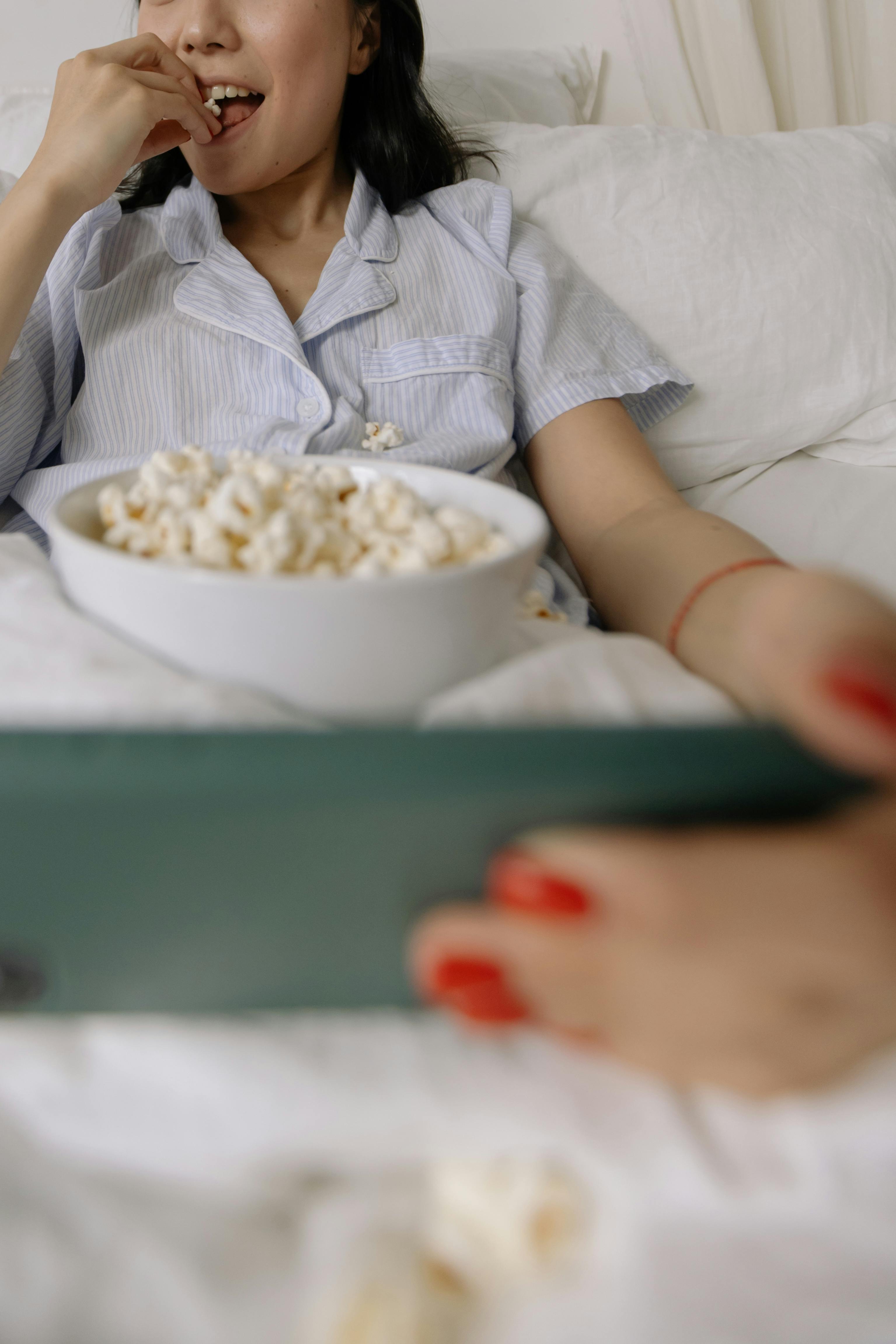 Woman Eats Popcorn in Bed · Free Stock Photo