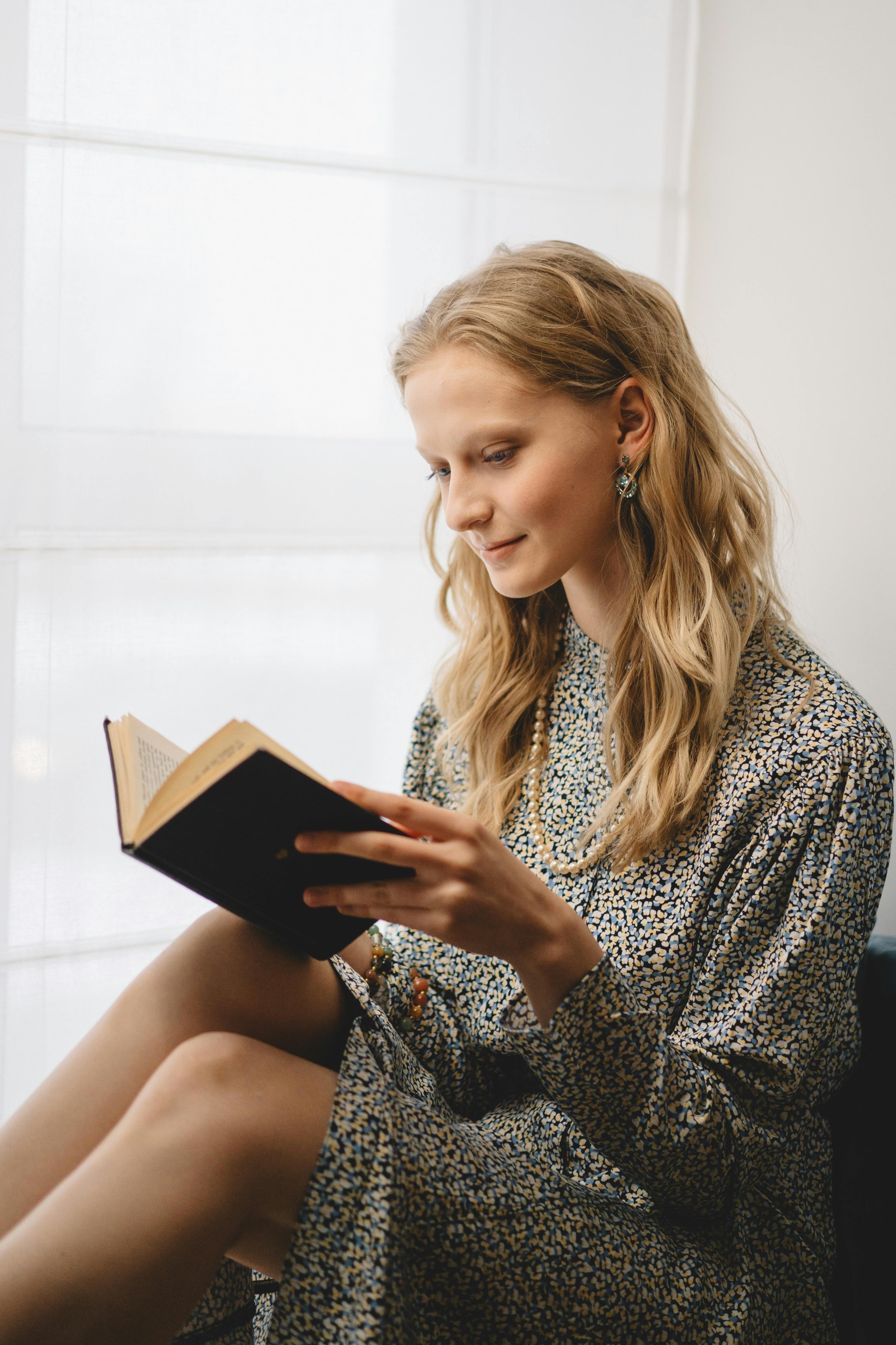 Woman Reading a Book While Sitting in Grass Field · Free Stock Photo