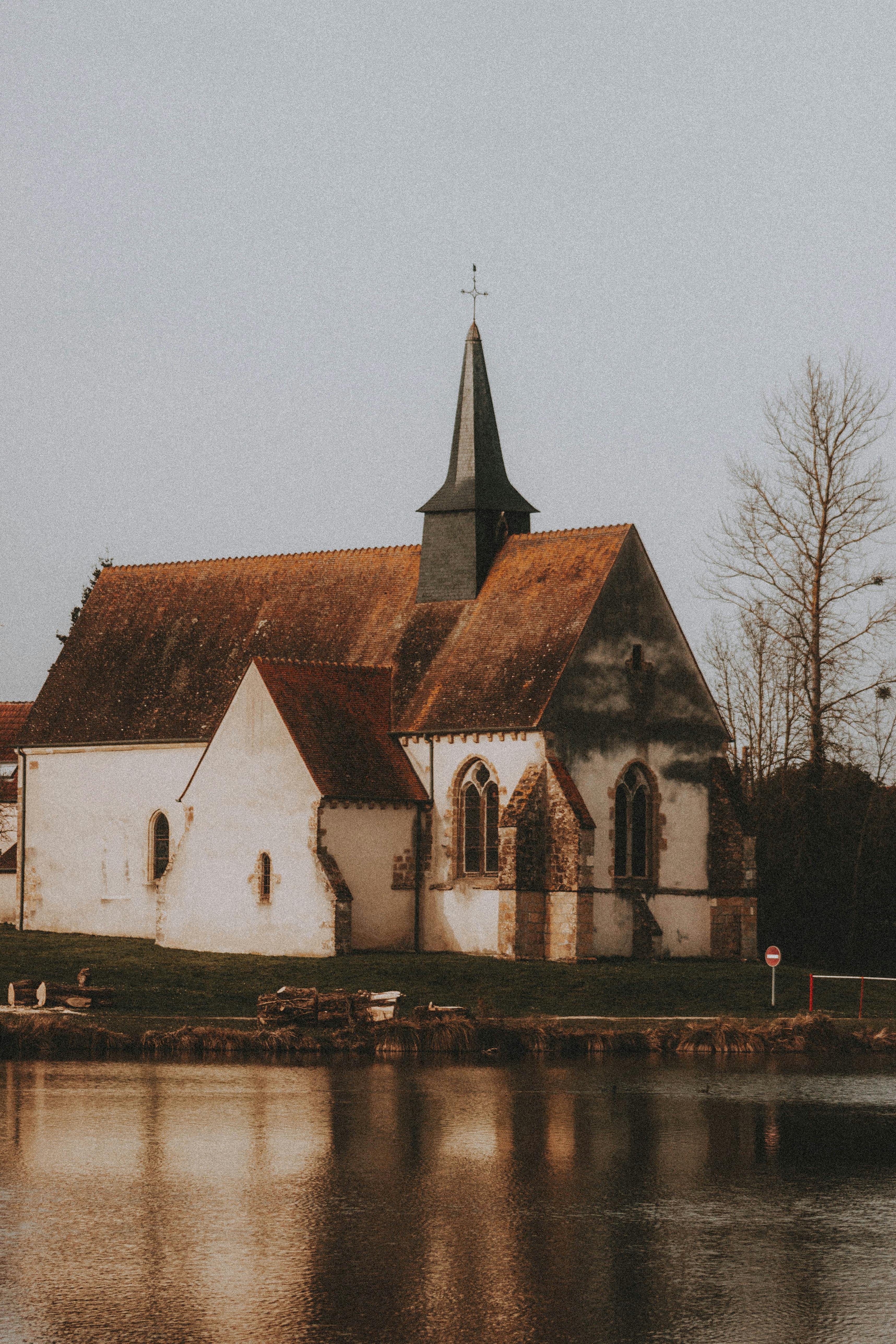 Old church near lake in countryside · Free Stock Photo