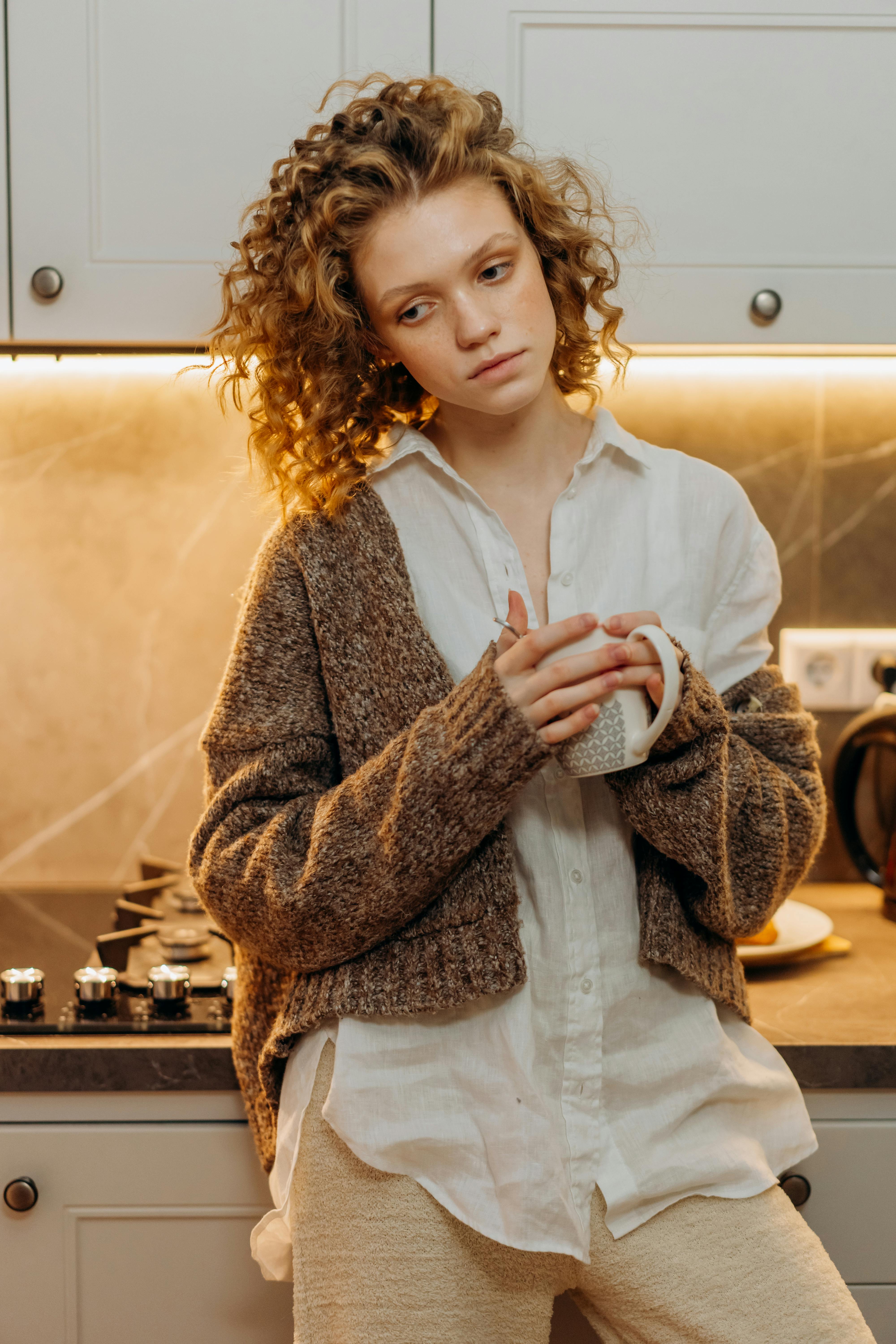 Woman in Brown Sweater in Front of a Reception Desk · Free Stock Photo