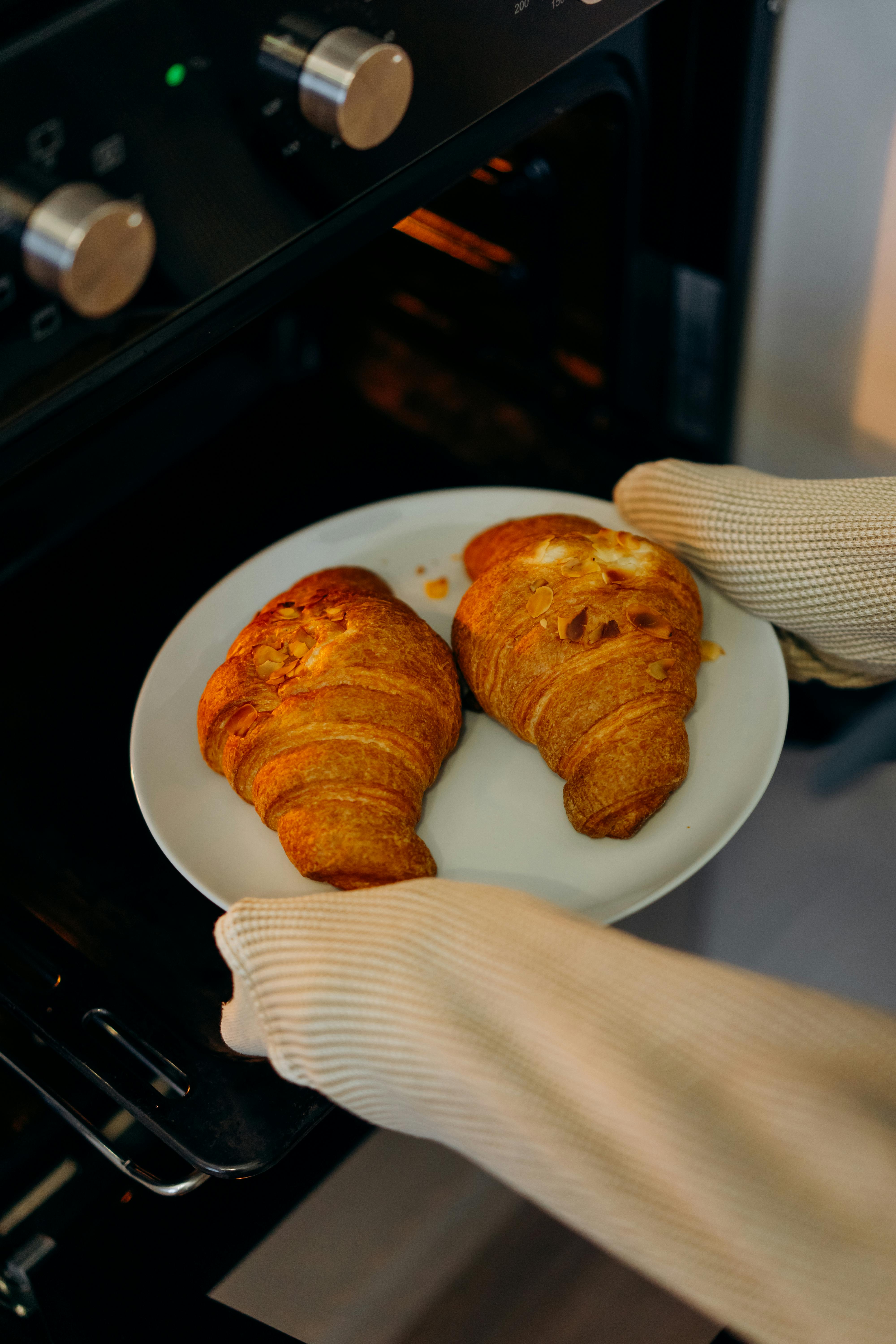 A Person Putting the Croissants Inside the Oven · Free Stock Photo