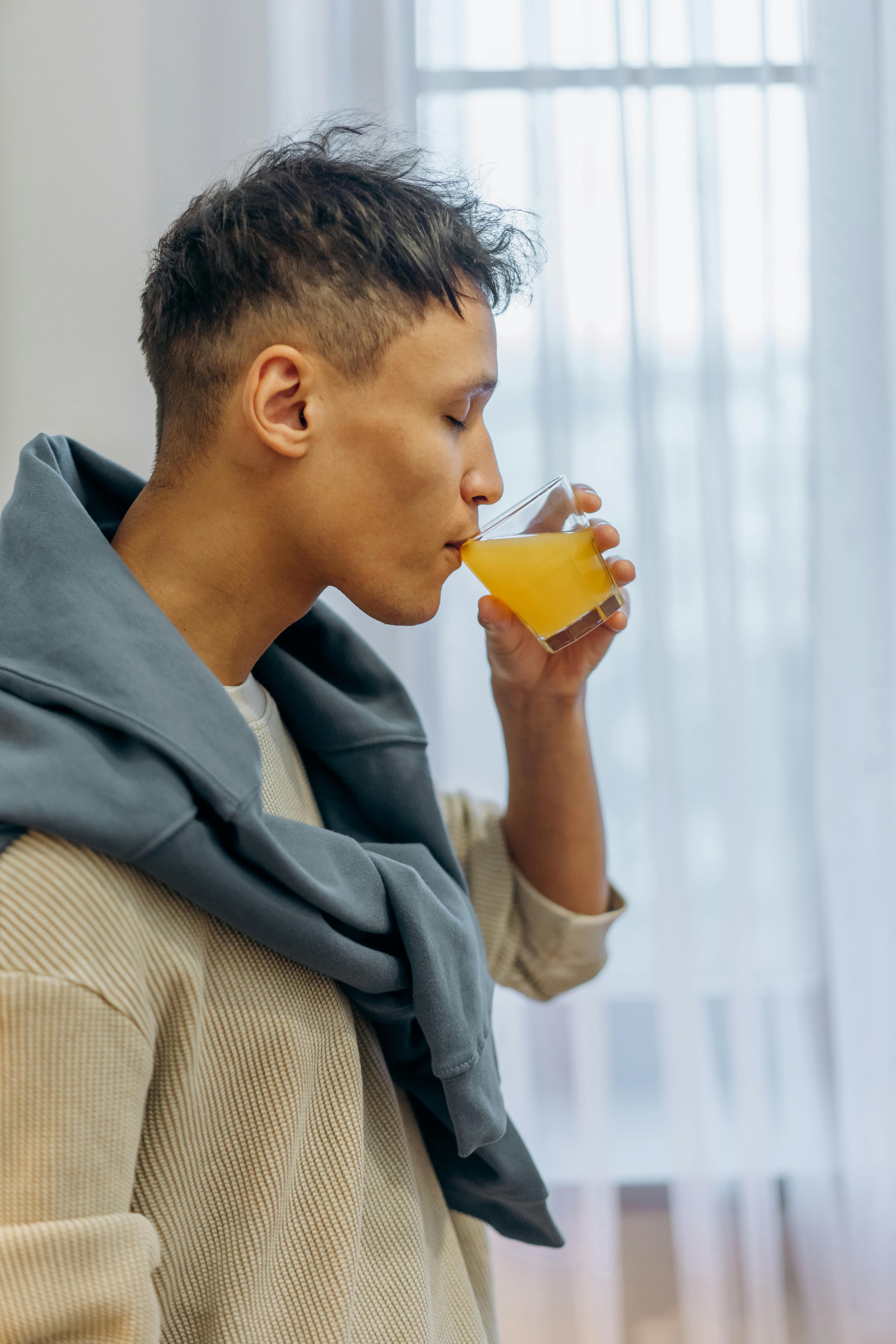 Side View Shot of a Man Drinking a Glass of Juice · Free Stock Photo