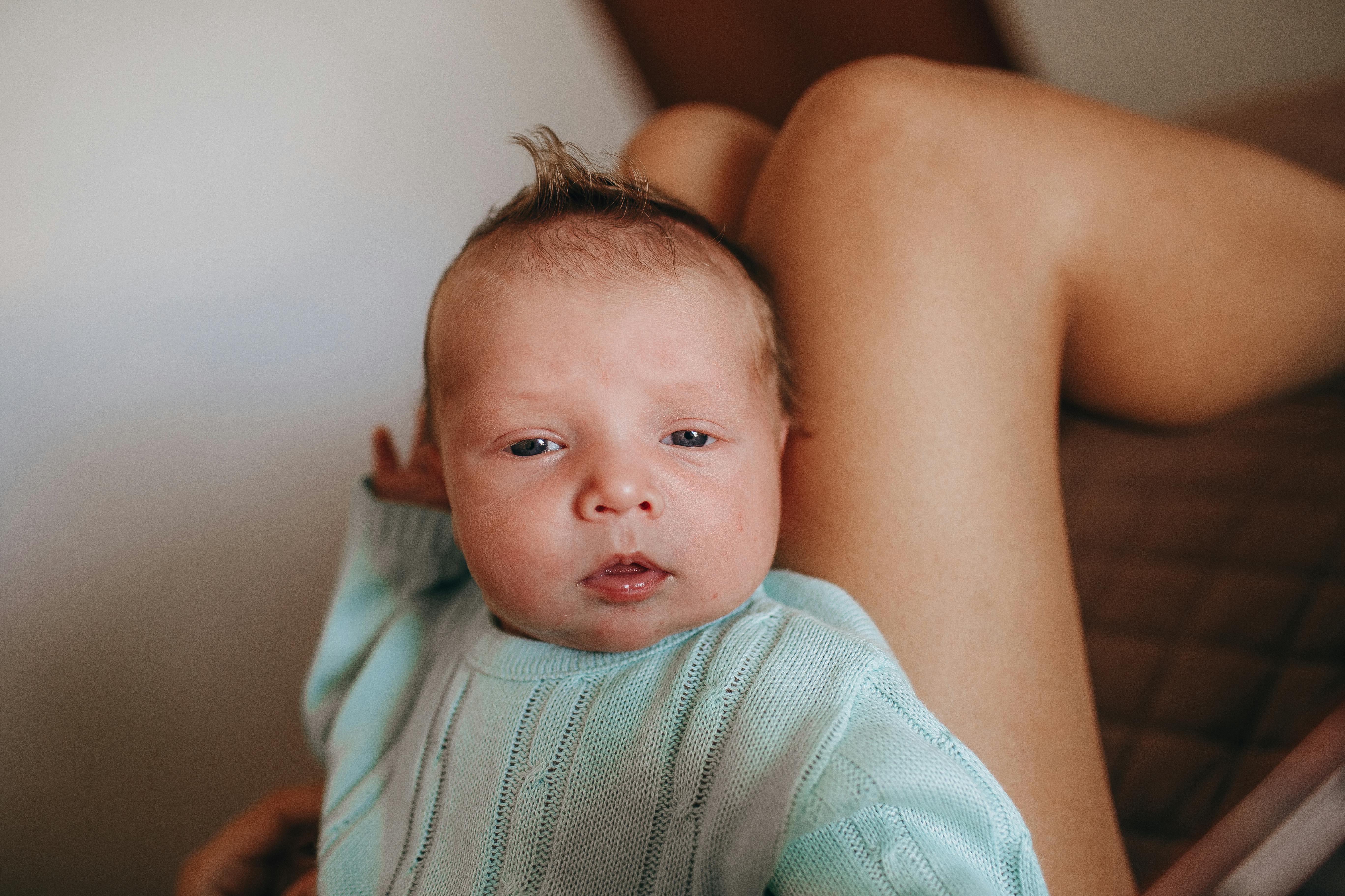 Faceless mother with baby on legs · Free Stock Photo