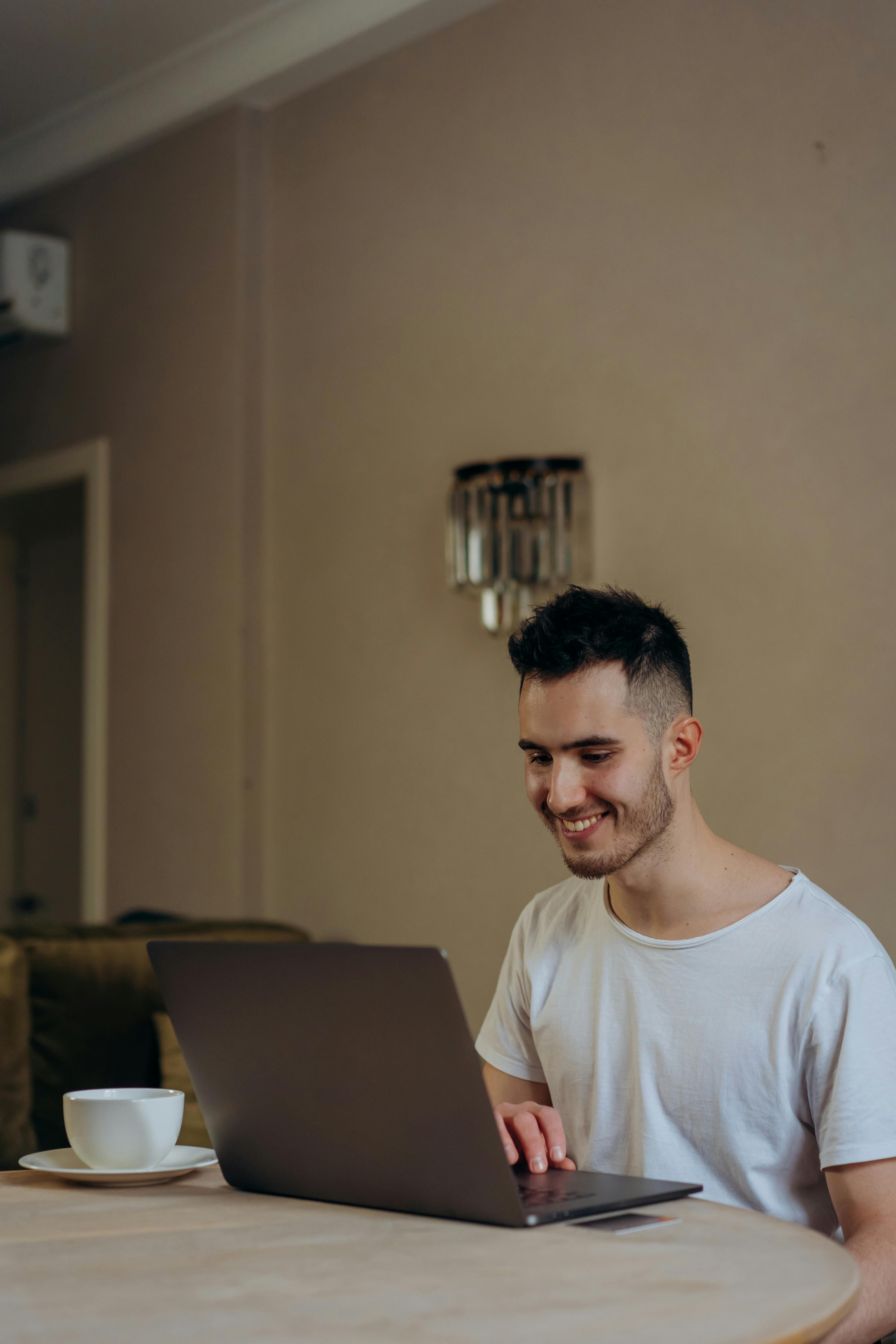 Woman Smiling While Using Laptop · Free Stock Photo