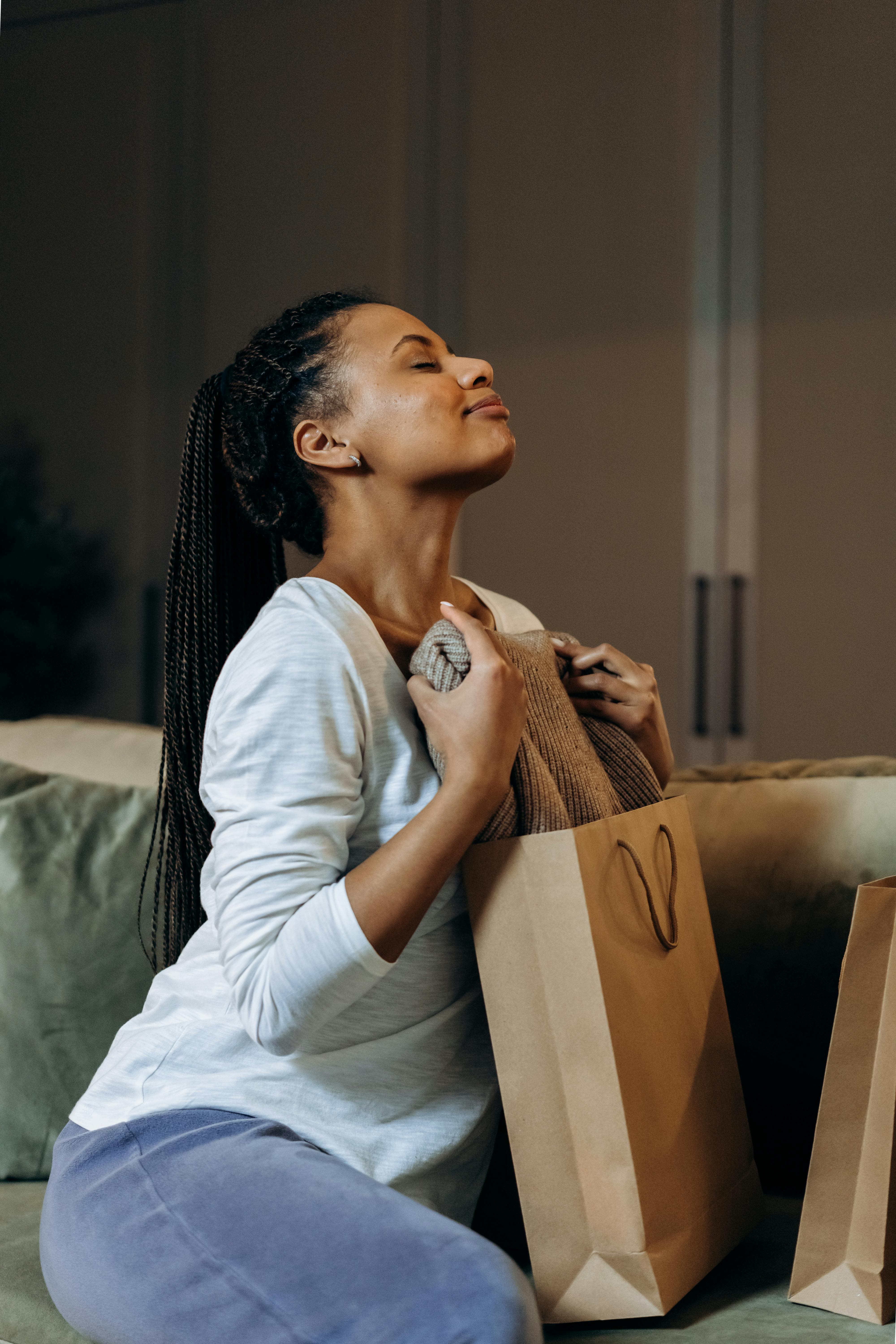 Woman Hugging a Fabric From a Brown Paper Bag · Free Stock Photo