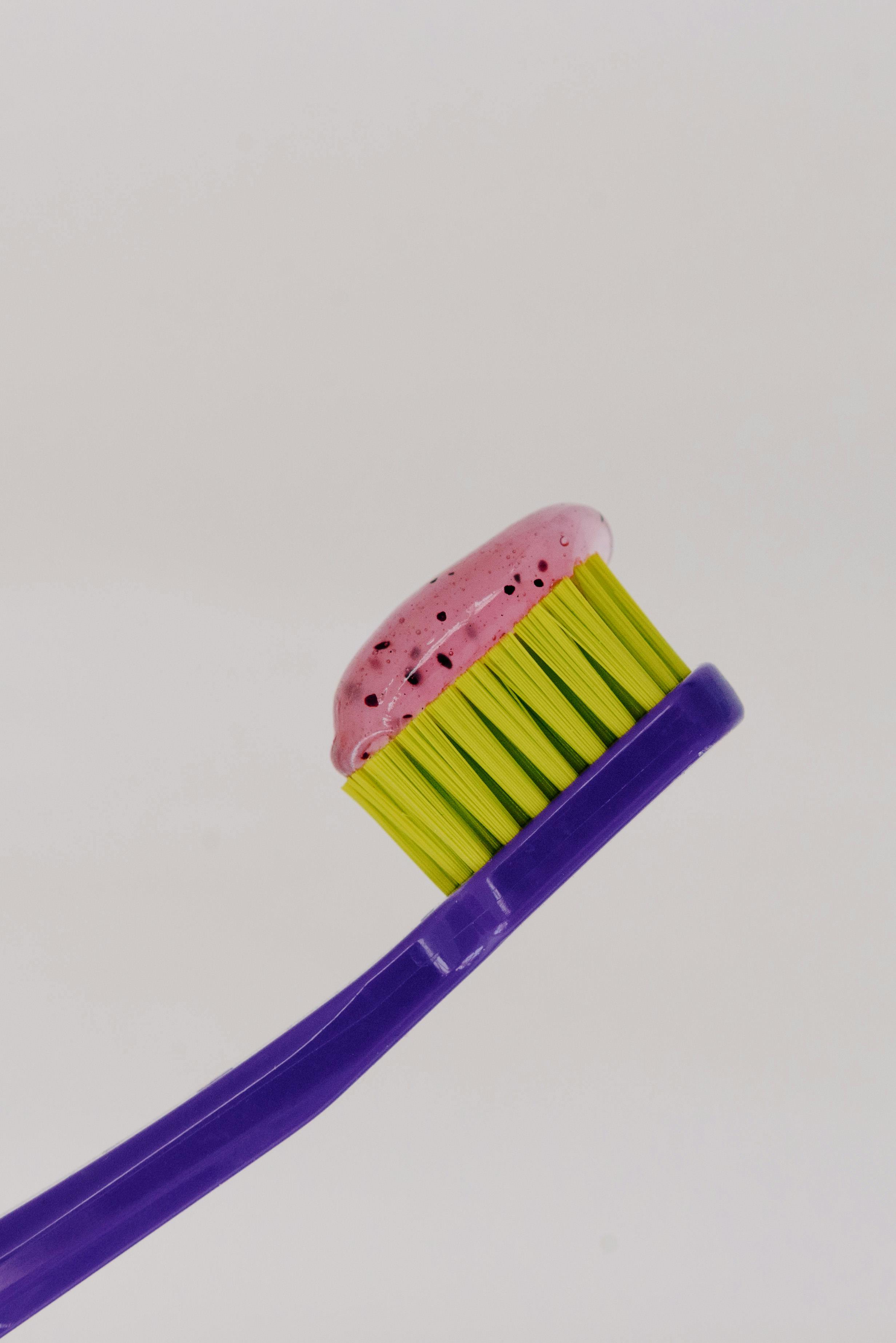 Yellow and Purple Toothbrush with Toothpaste · Free Stock Photo