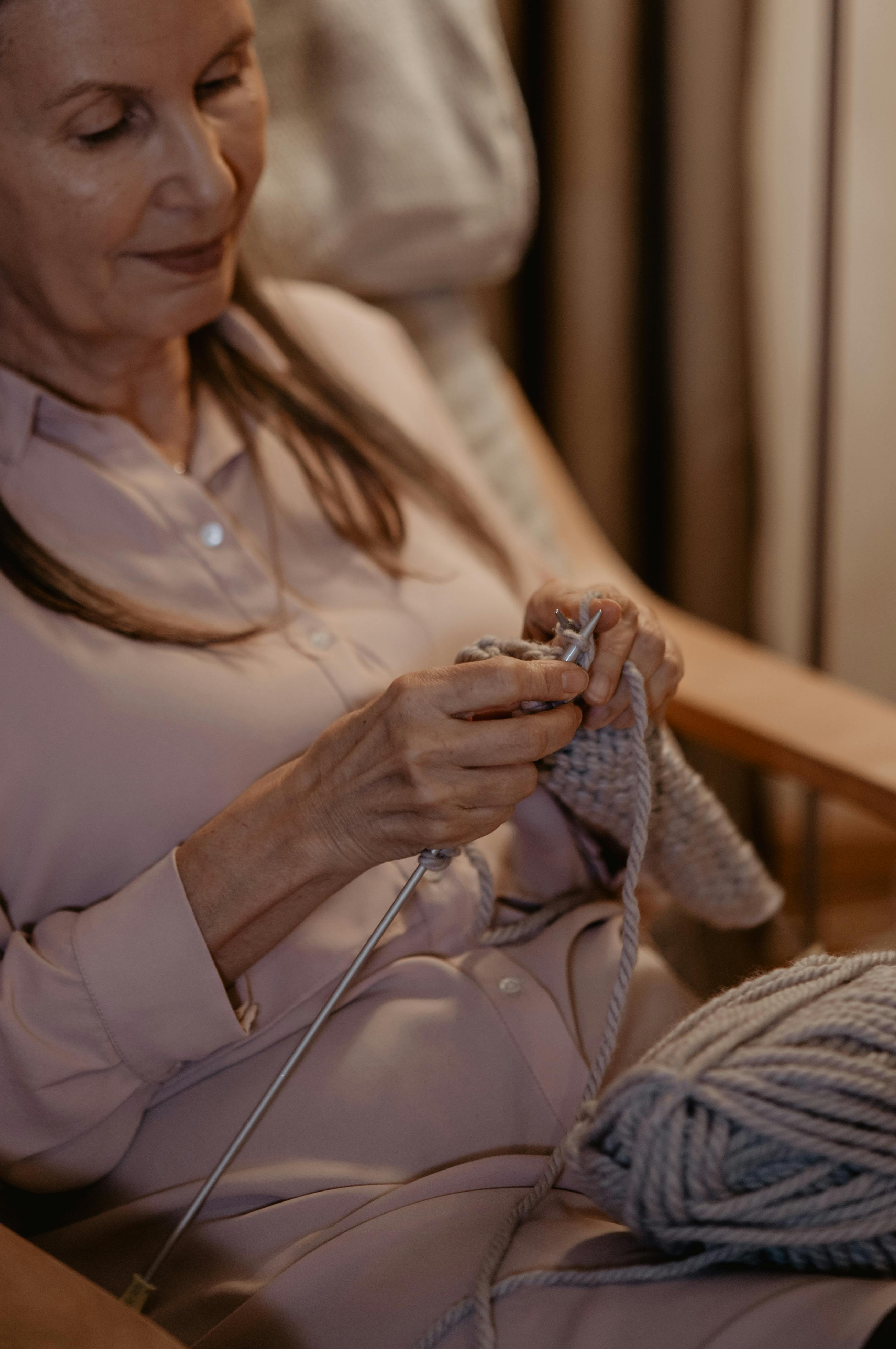 A Woman Crocheting while Sitting · Free Stock Photo