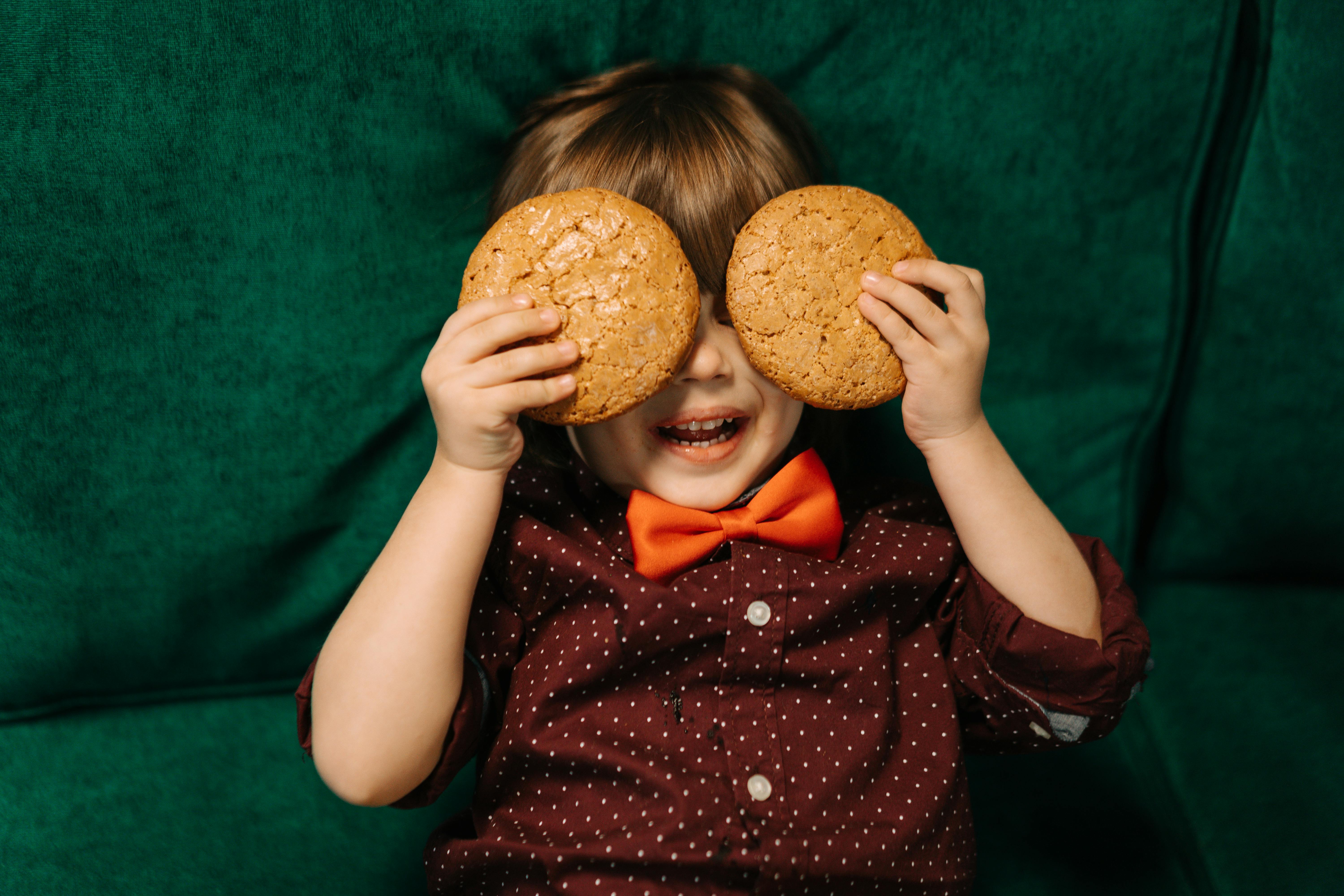Girl Holding Cookies over Face · Free Stock Photo