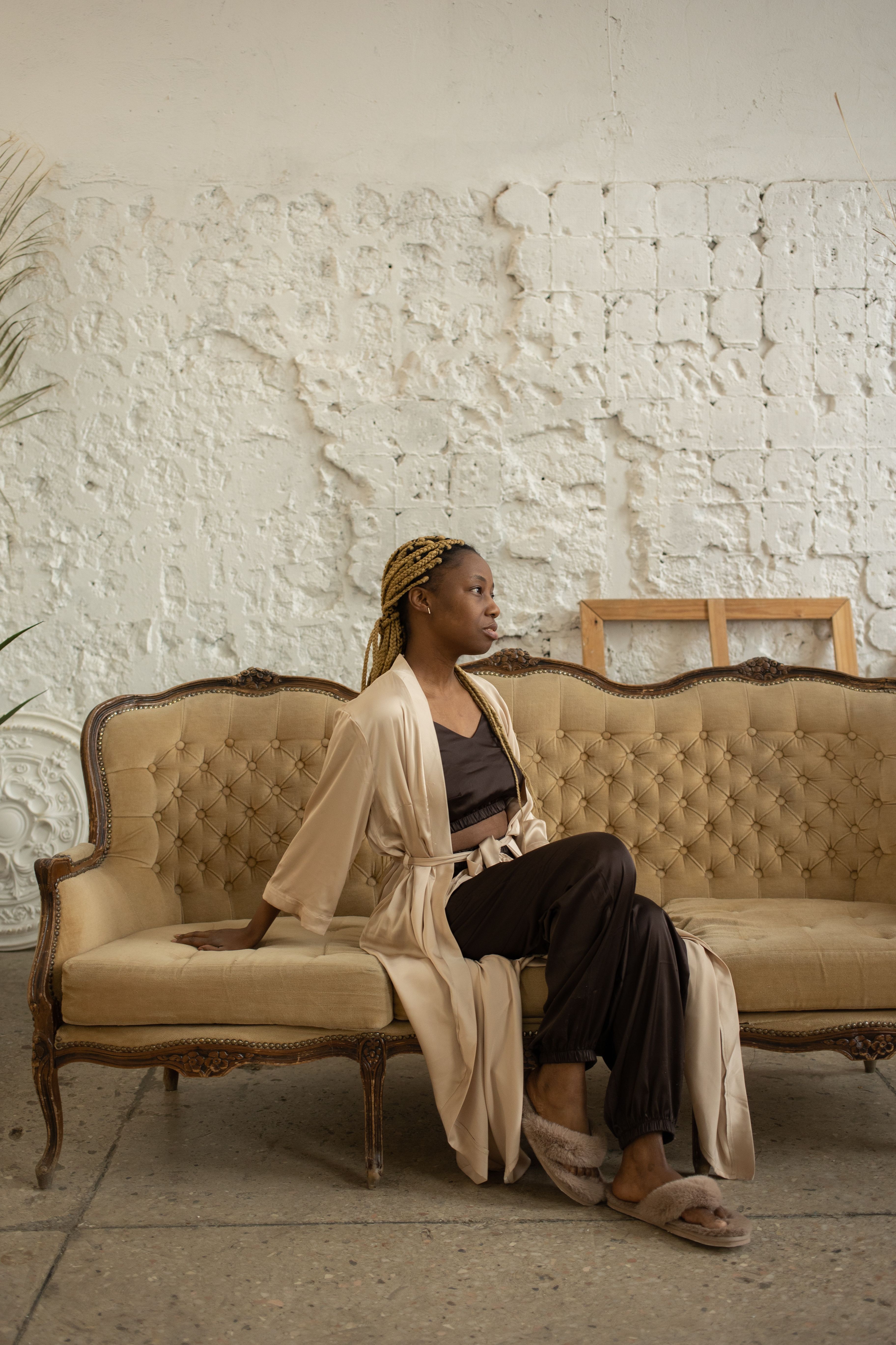 Woman in Beige Robe Sitting on a Sofa · Free Stock Photo