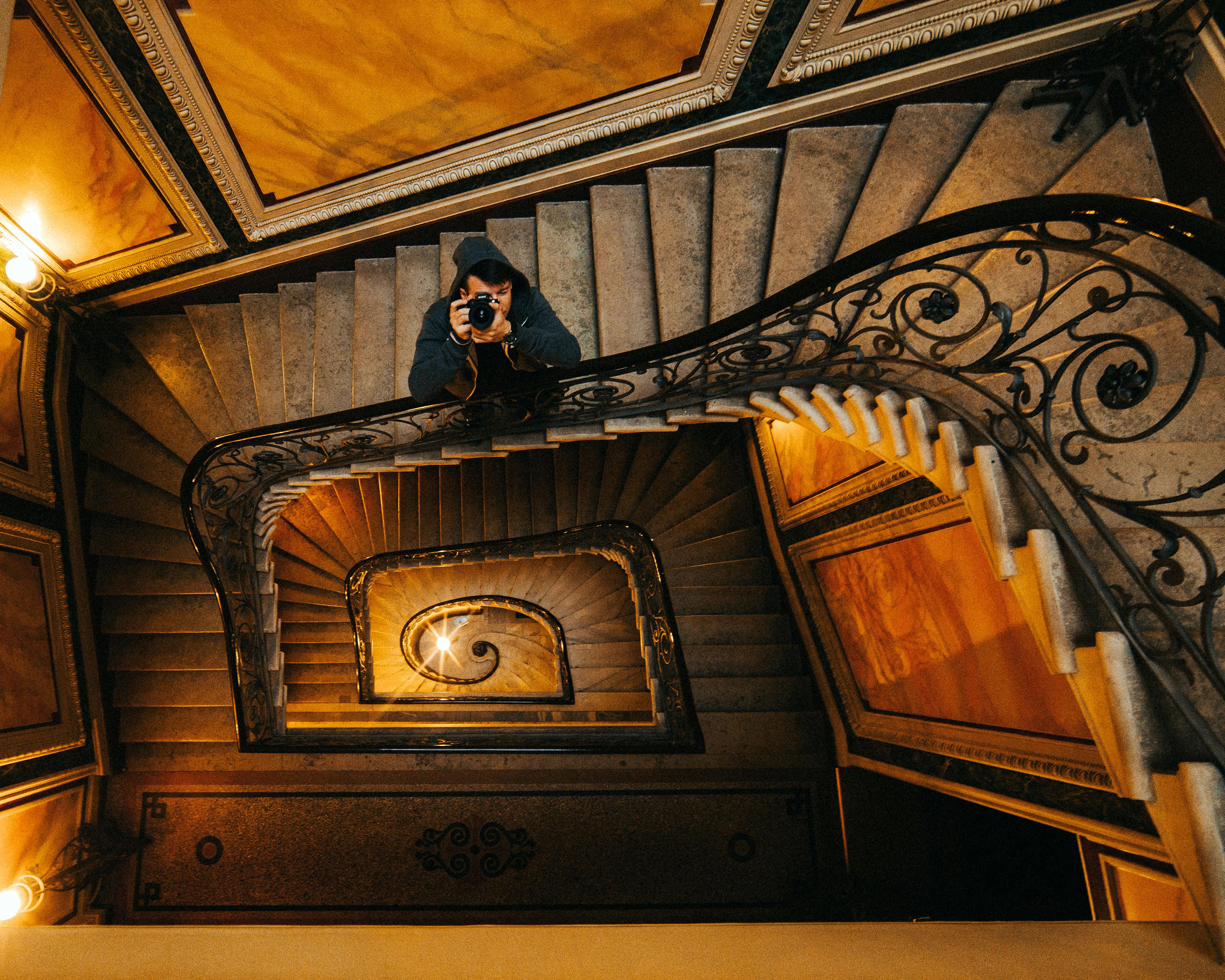 A Photographer on a Spiral Staircase · Free Stock Photo
