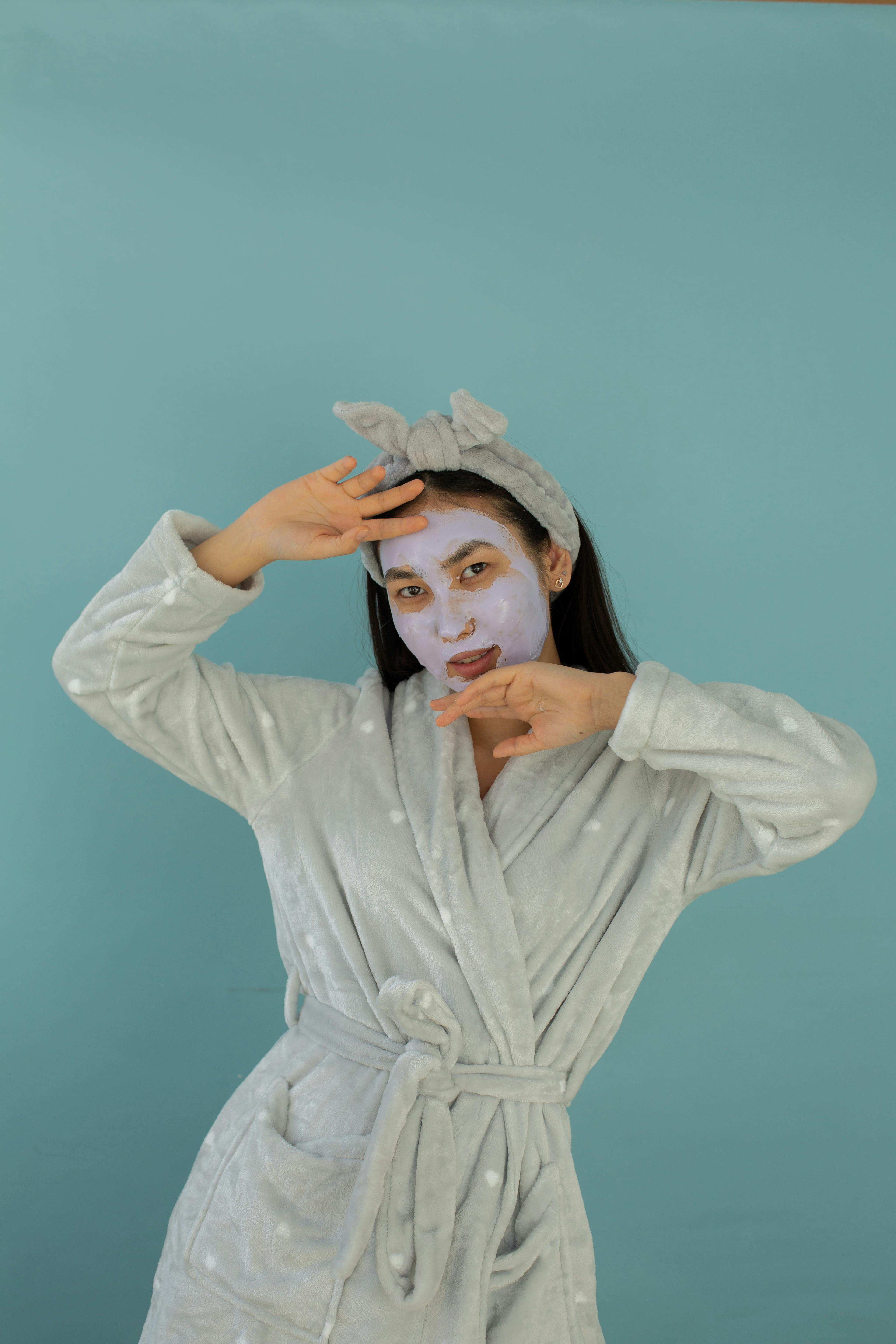 A Woman in a Robe Sitting on a Poolside · Free Stock Photo