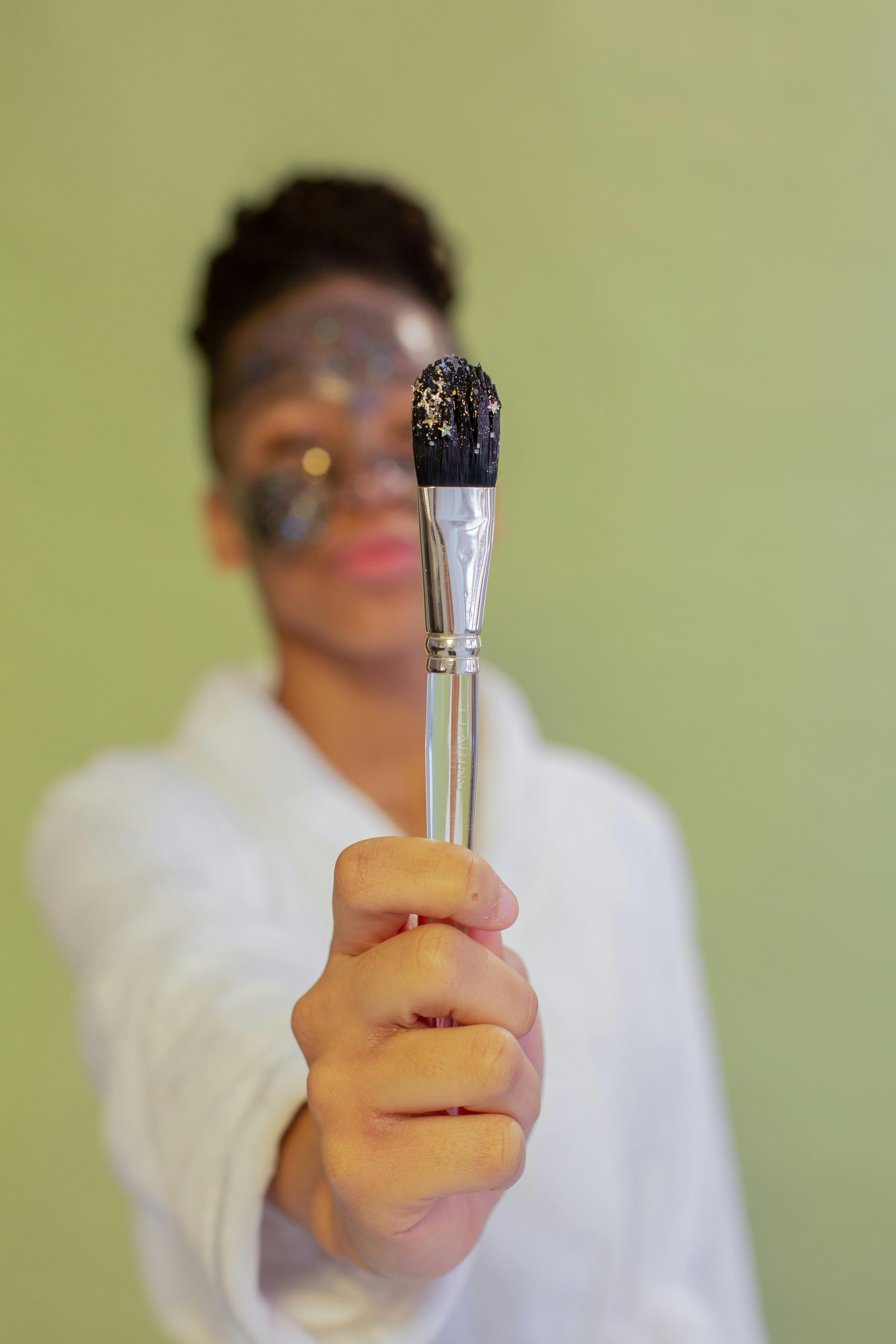 A Man Mixing Cream in a Container with a Brush · Free Stock Photo
