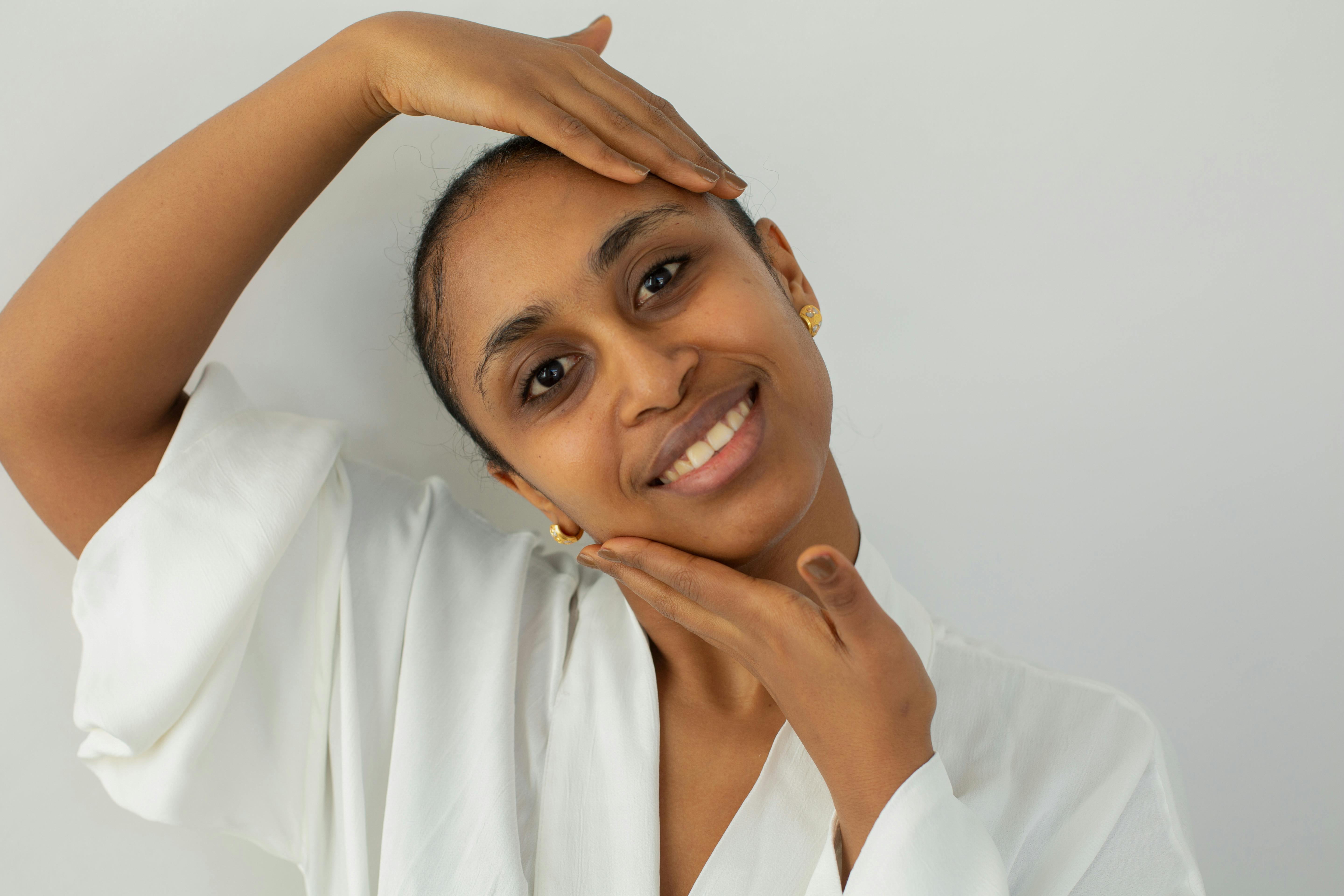 Smiling black model with Afro braids on gray background · Free Stock Photo