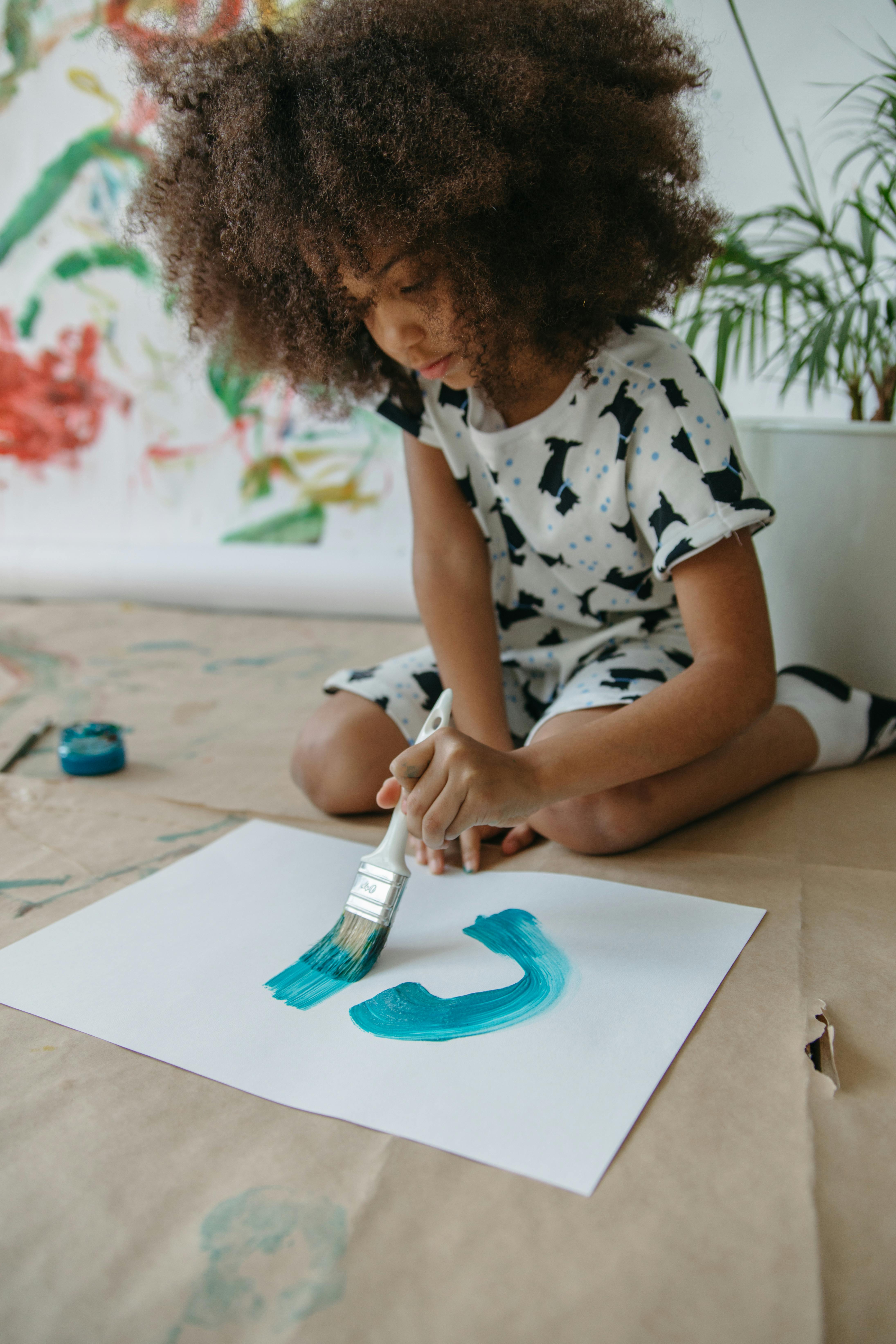 A Kid Painting on a White Paper · Free Stock Photo