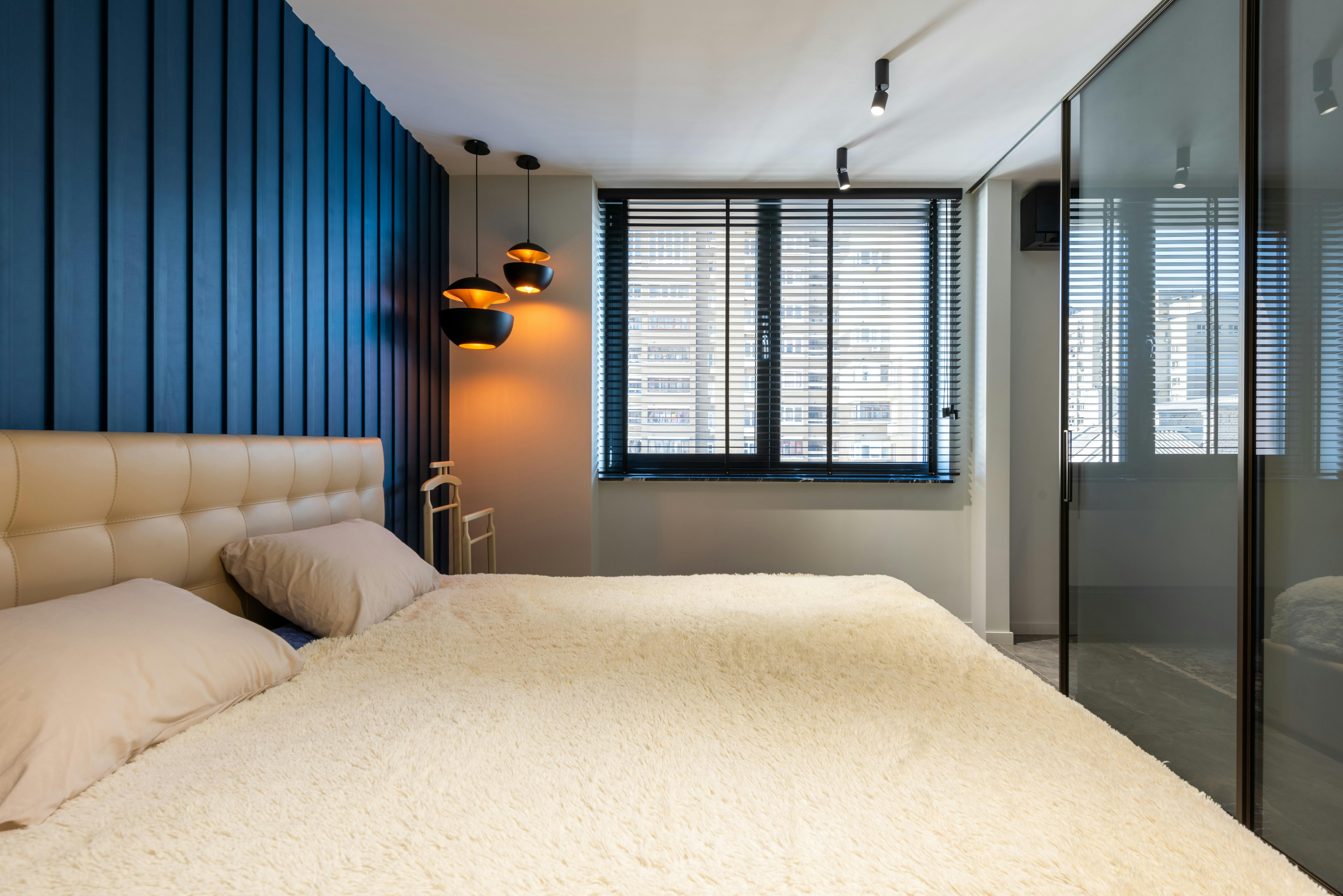 Modern bedroom interior with bed against window in flat · Free Stock Photo