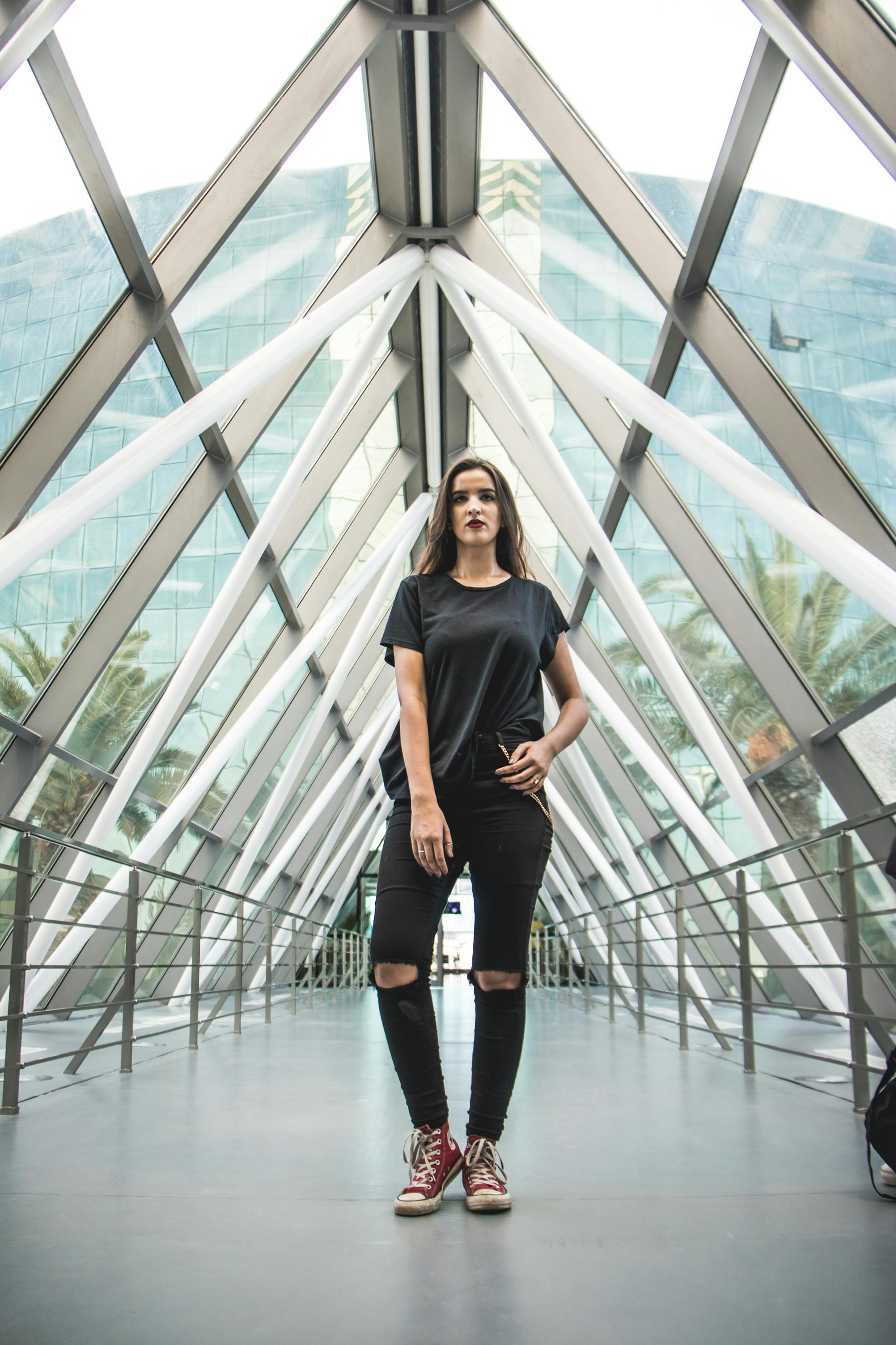 Woman Wearing Ripped Jeans Posing Beside a Wall · Free Stock Photo