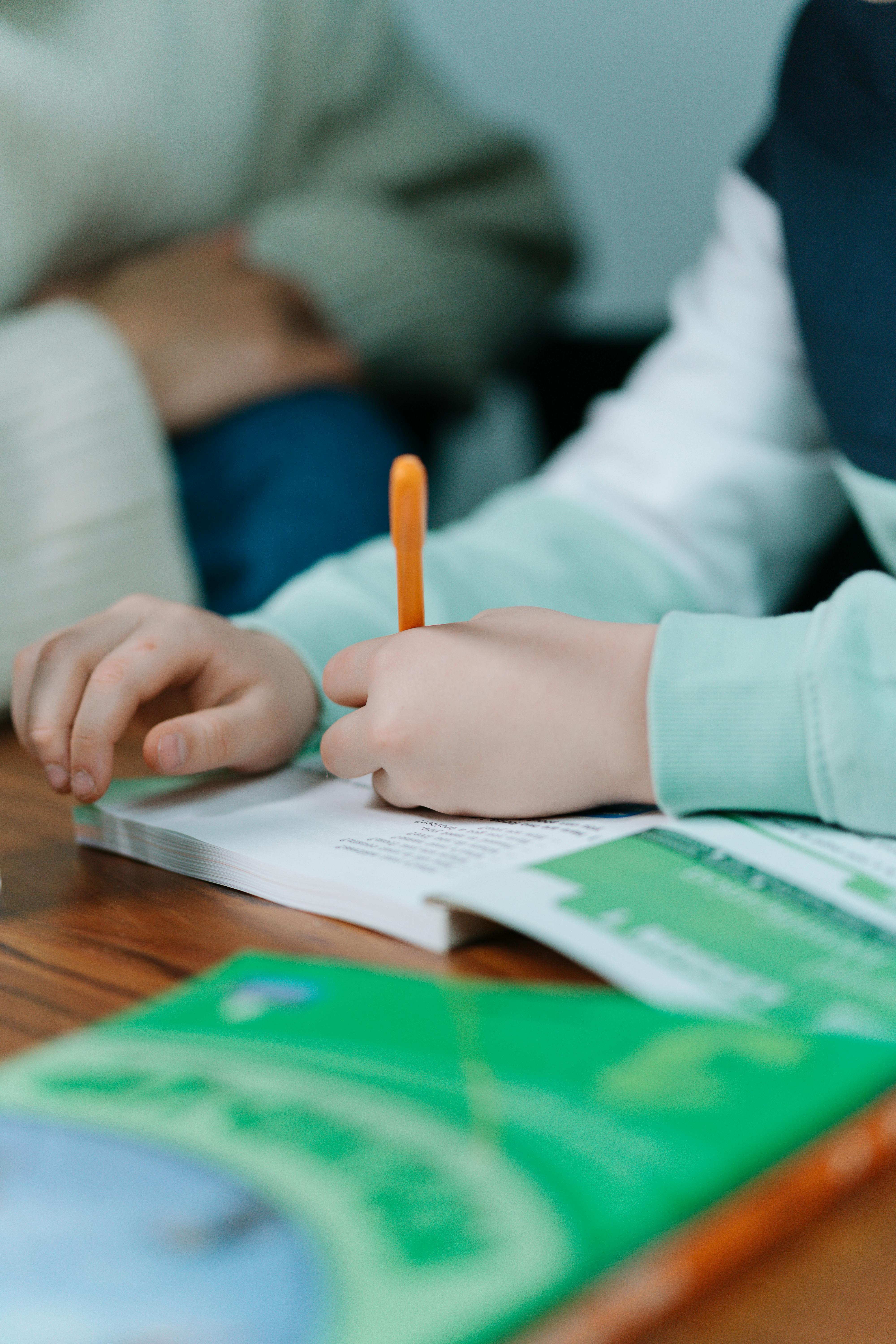 Hands Writing on Book · Free Stock Photo