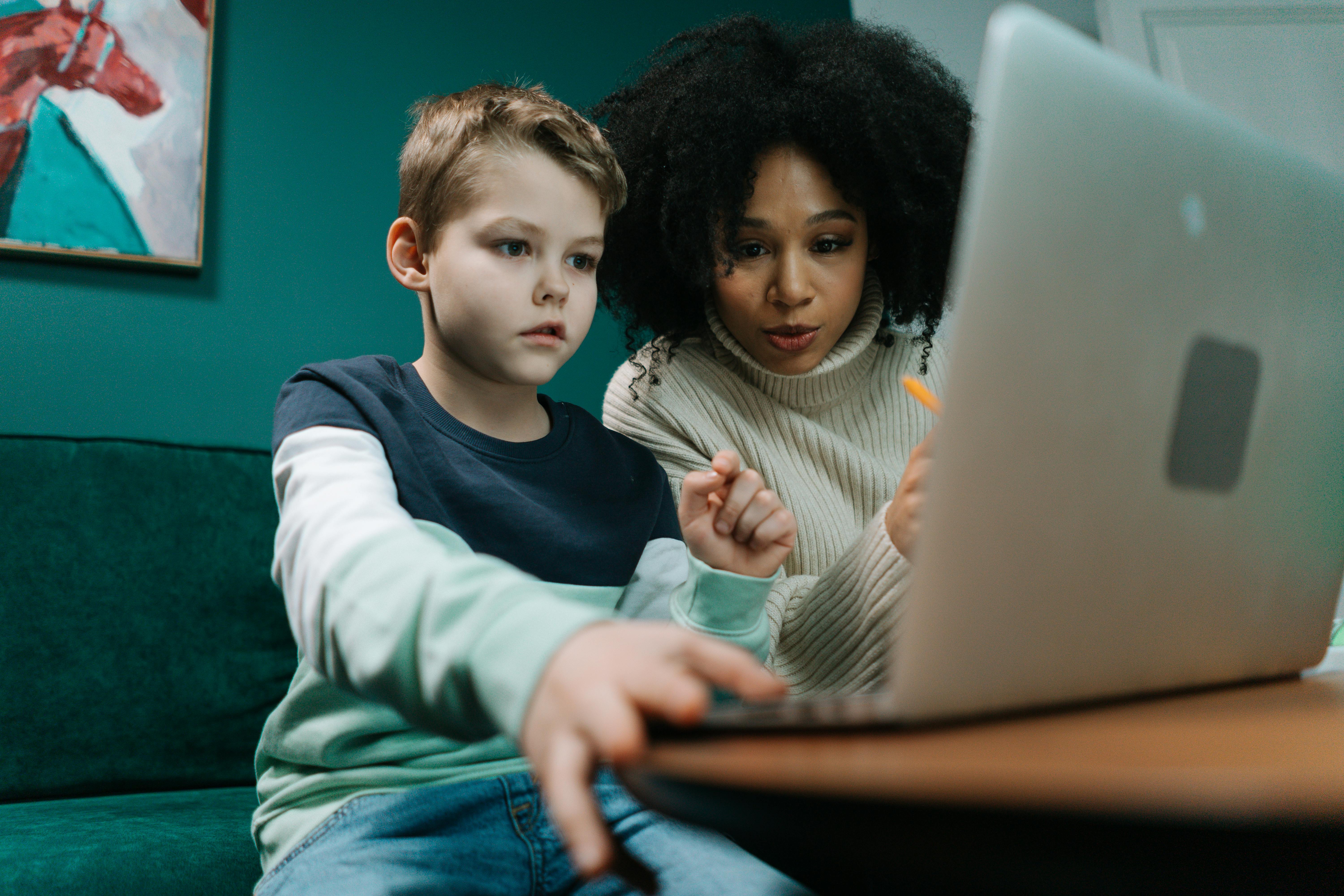 A Woman and a Kid Looking at the Screen of a Laptop · Free Stock Photo