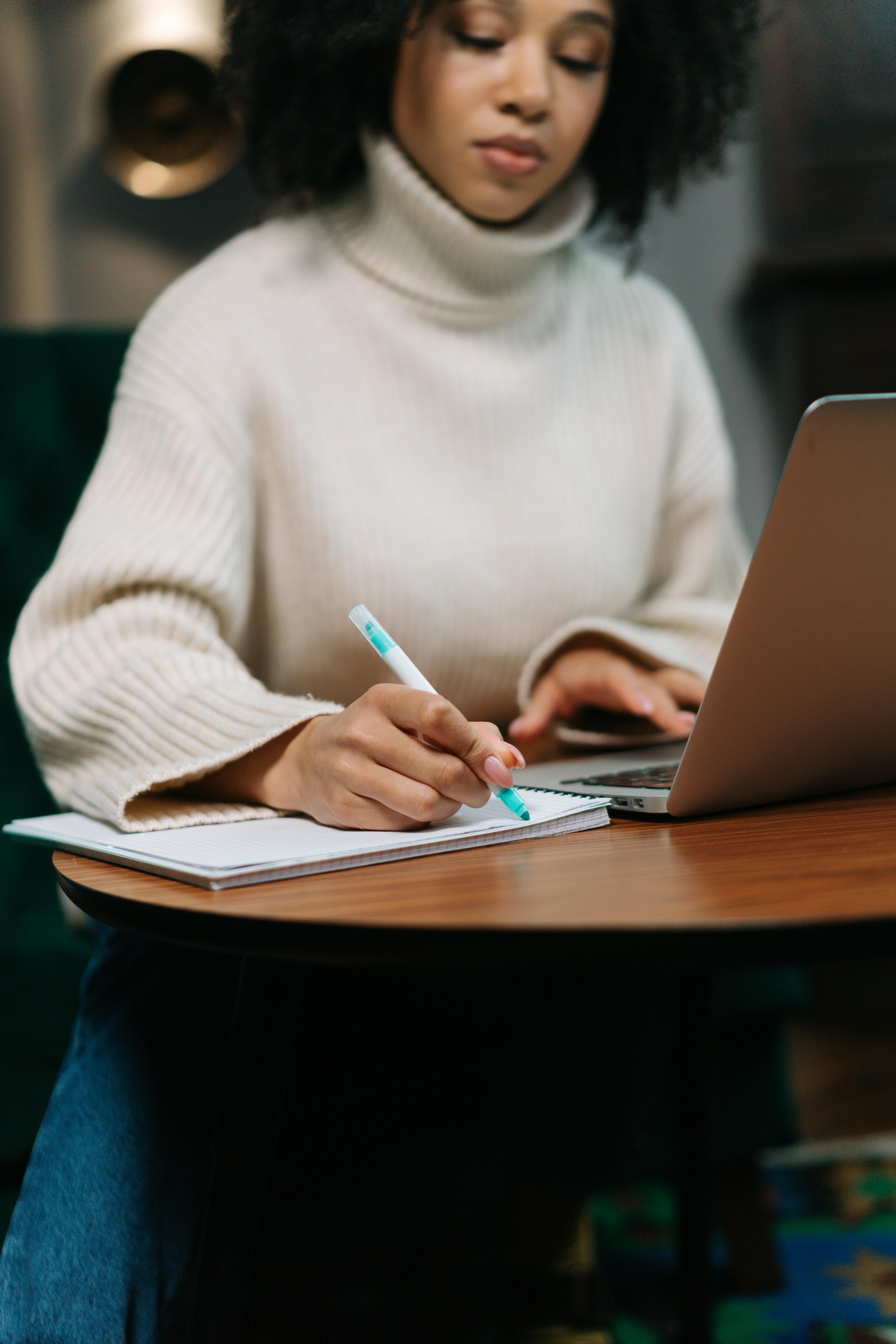Woman Sitting and Writing in Notebook · Free Stock Photo