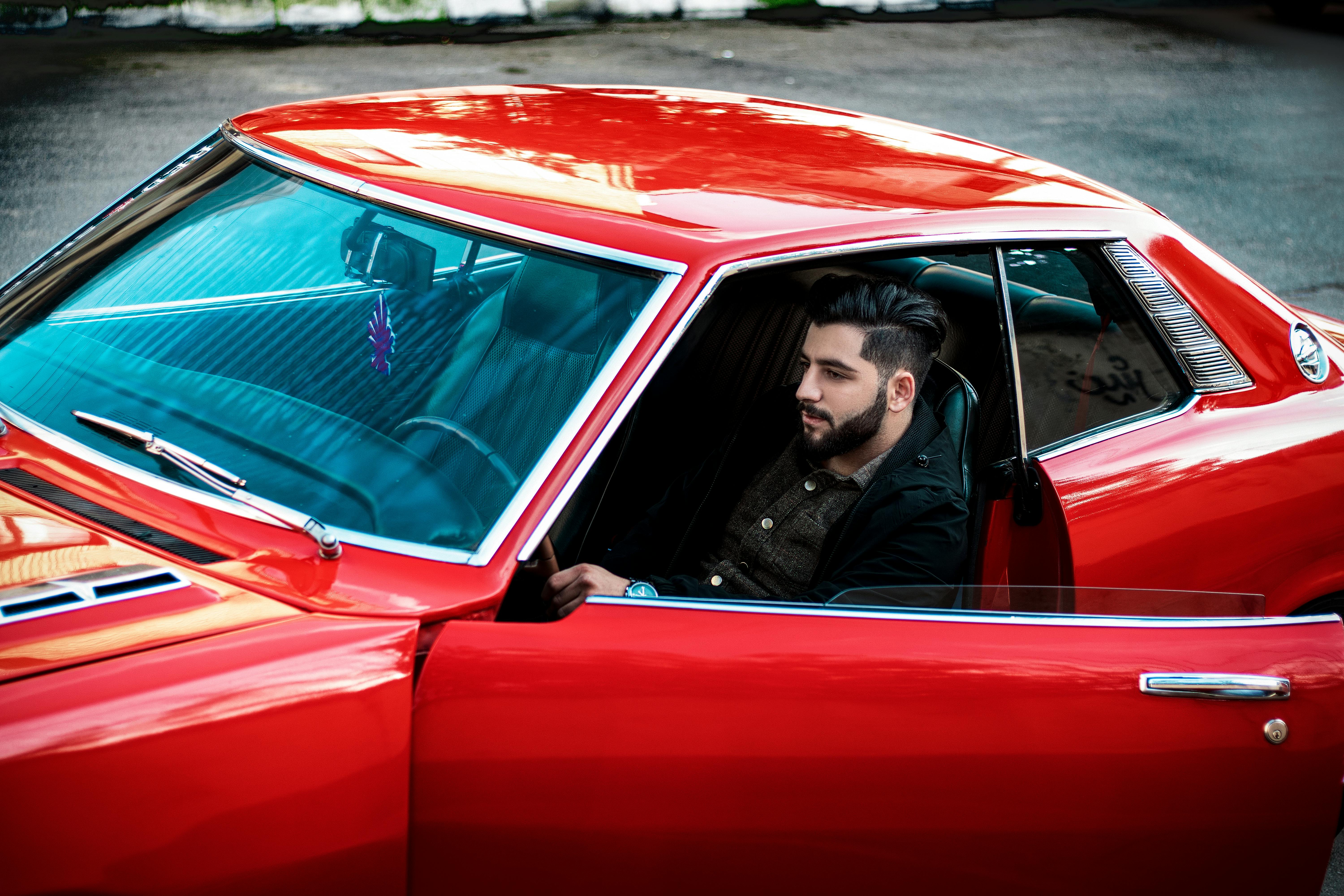 A Handsome Man Sitting Inside the Red Car · Free Stock Photo