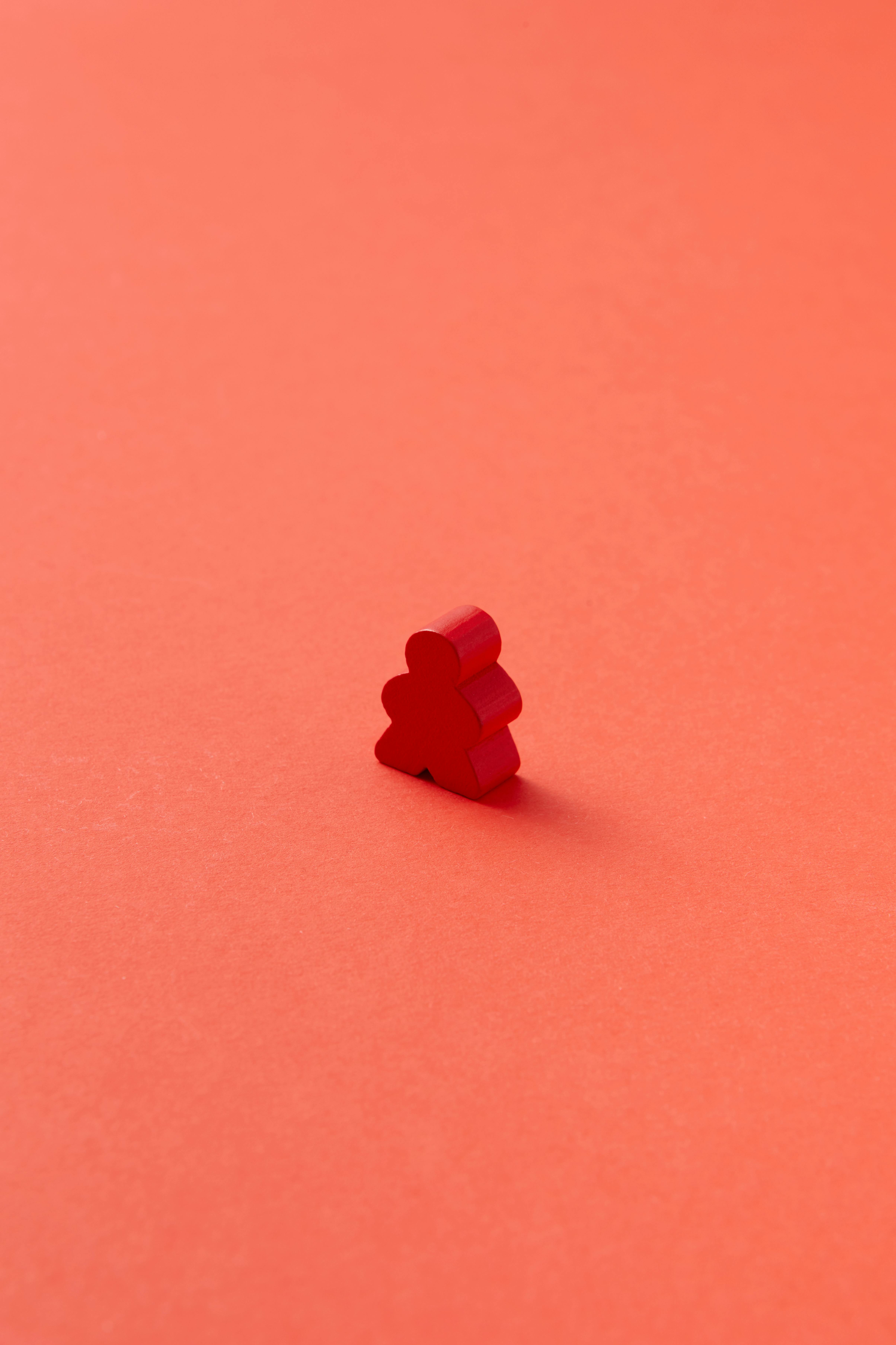 Photo of a Meeple Piece on a Red Surface · Free Stock Photo