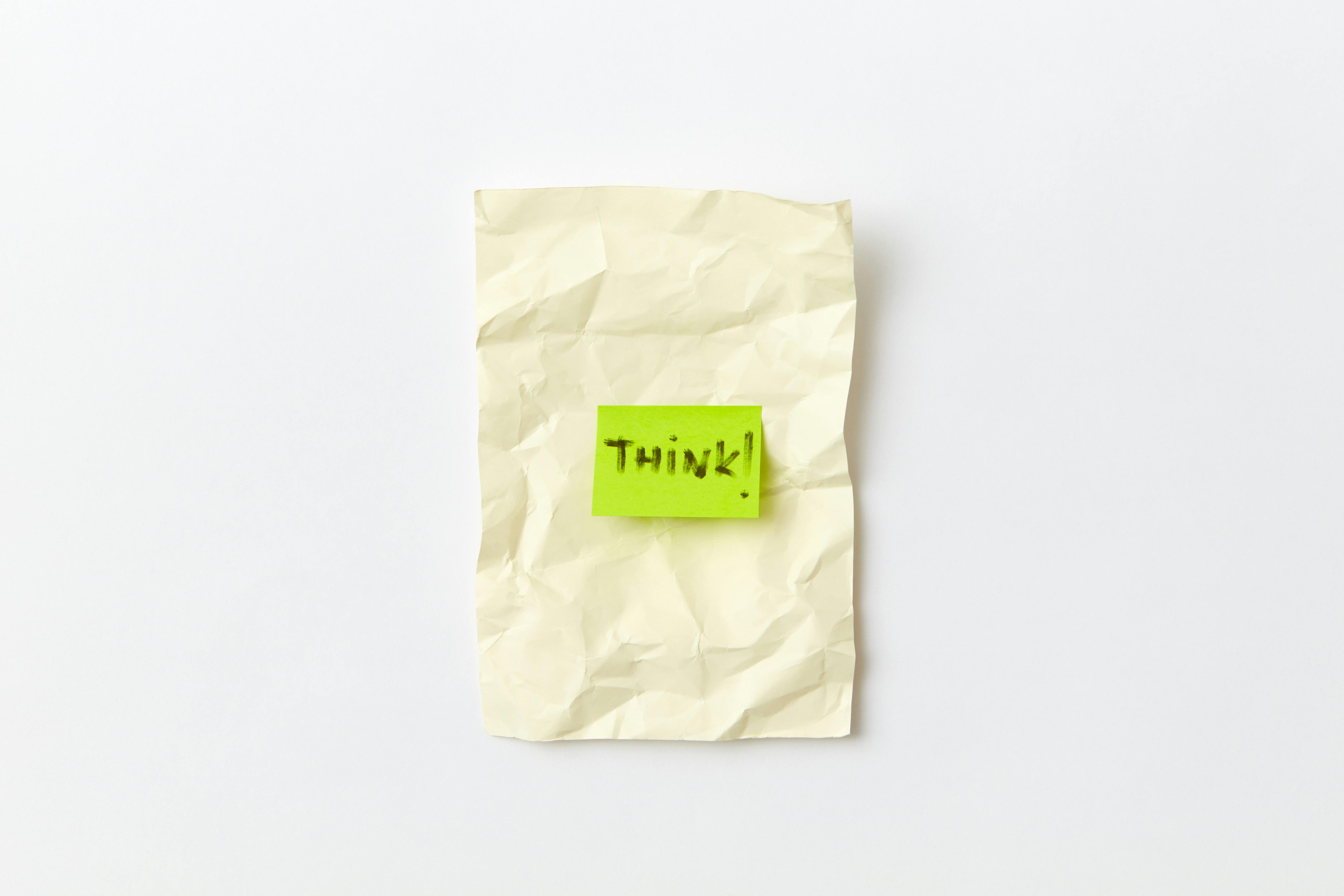 A Sticky Note with a Word on a Creased Paper · Free Stock Photo