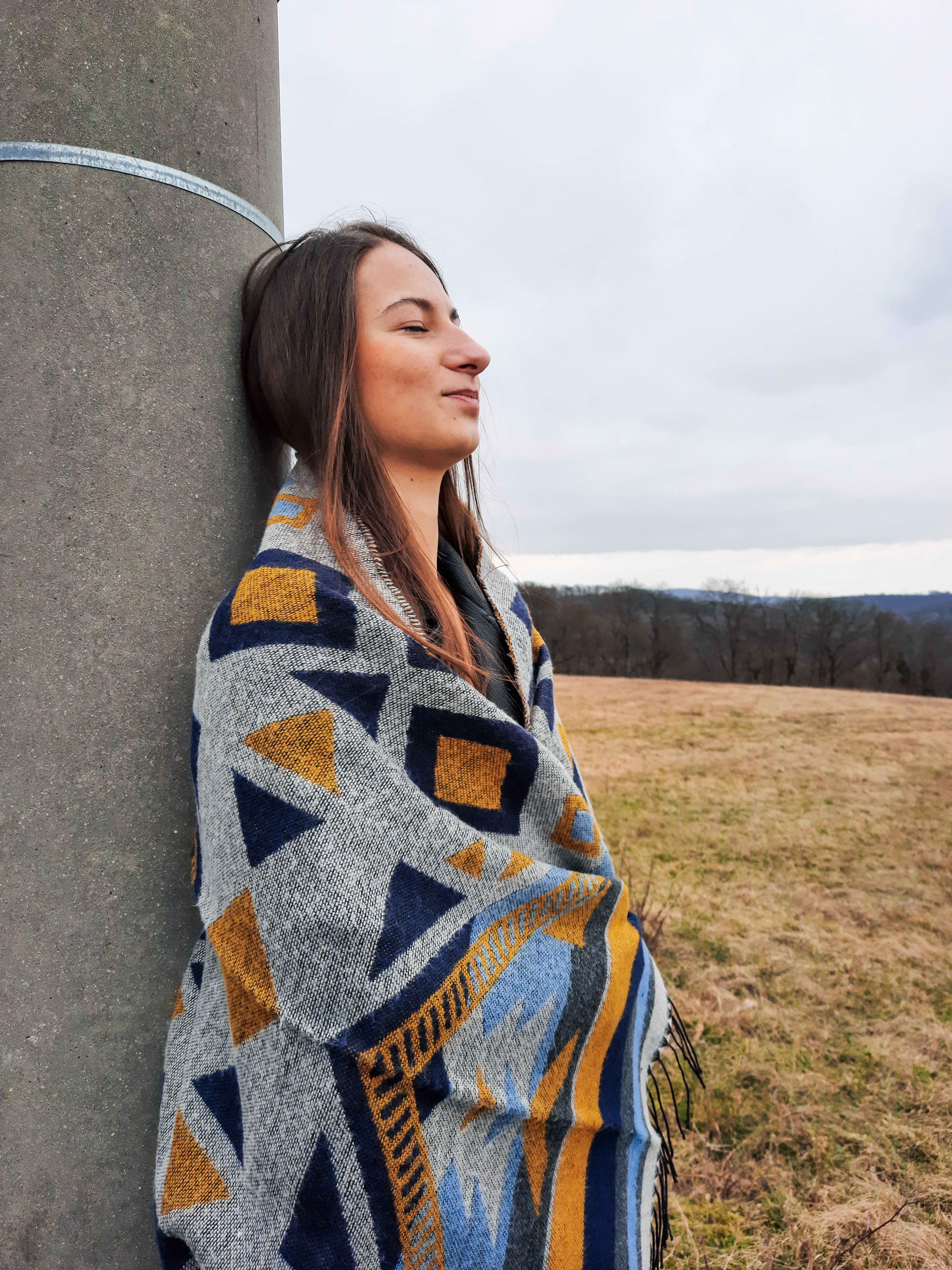 Woman in Blue and Gray Shawl Leaning on Concrete Pole · Free Stock Photo