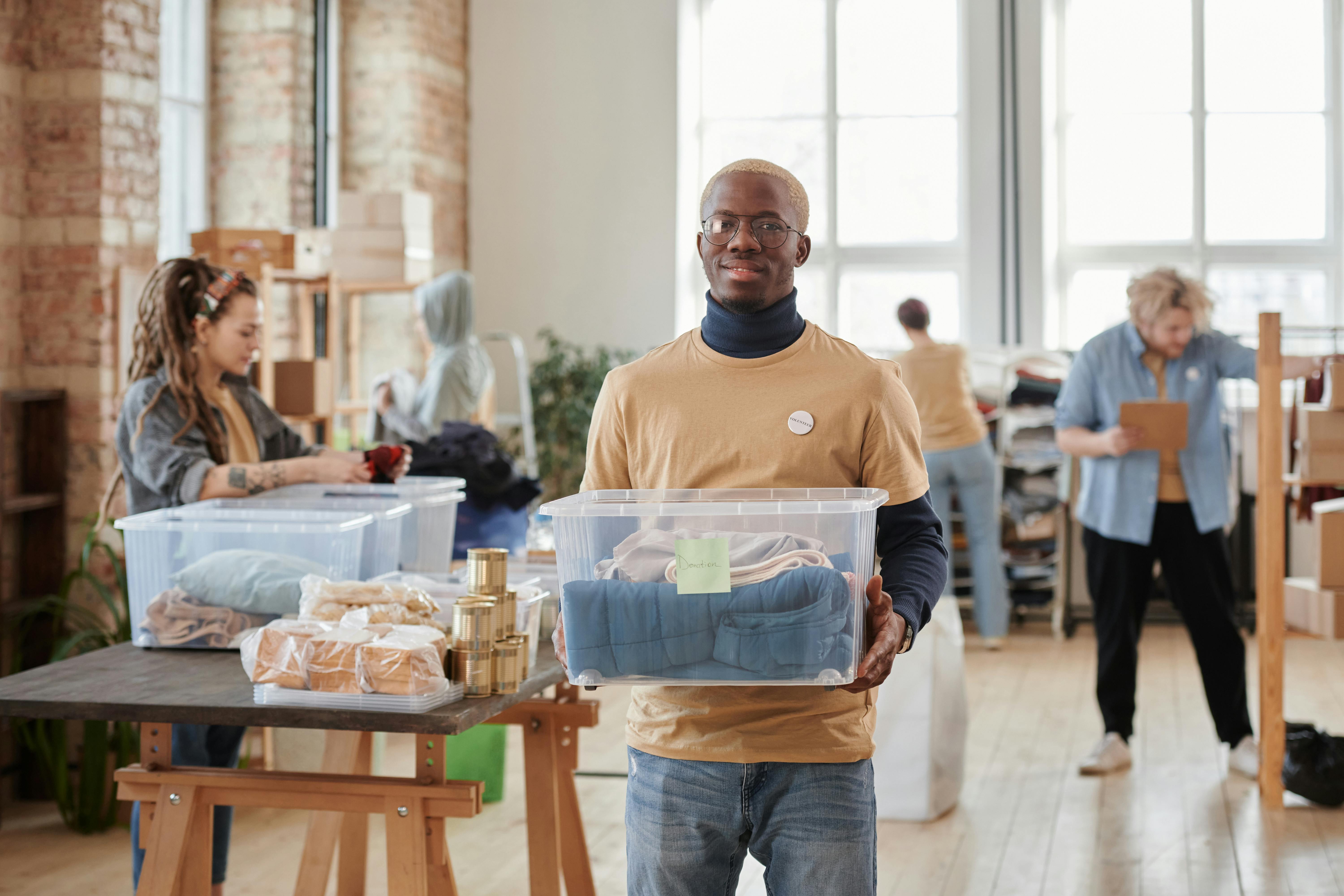 A Group of Volunteers Sorting Clothes into Containers · Free Stock Photo